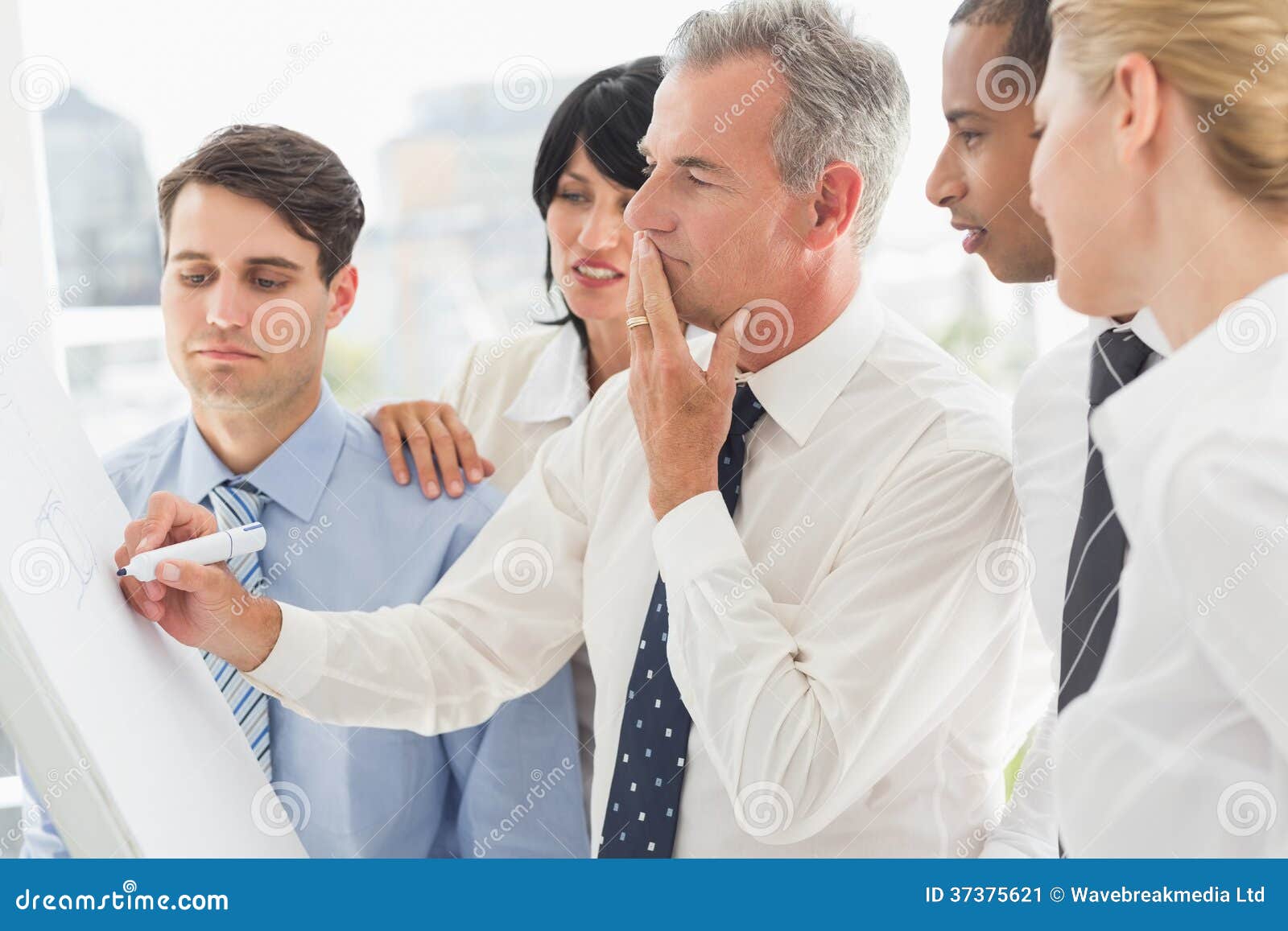 Colleagues Watching Thinking Businessman Writing on Whiteboard Stock ...