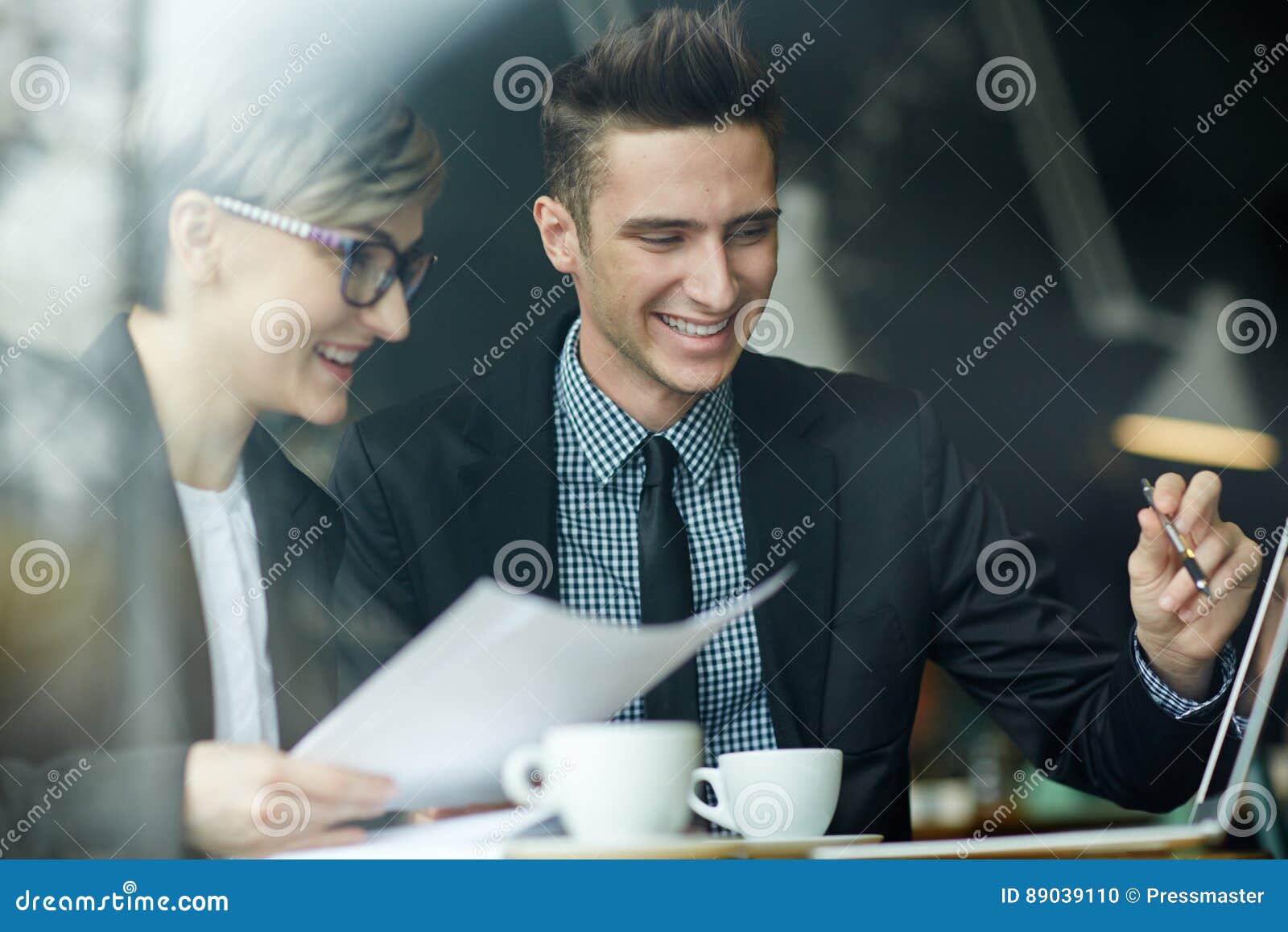 Colleagues Wrapped Up in Work Stock Photo - Image of sitting, cafe ...