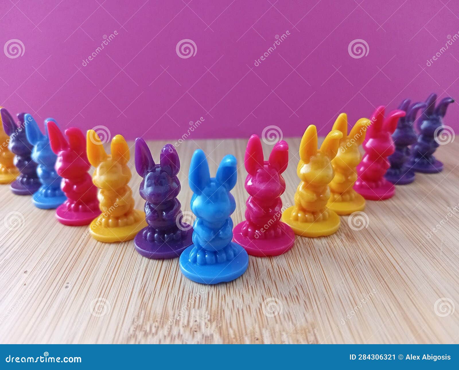 Collection of Colorful Toy Bunny Figures on a Pink Background Stock ...