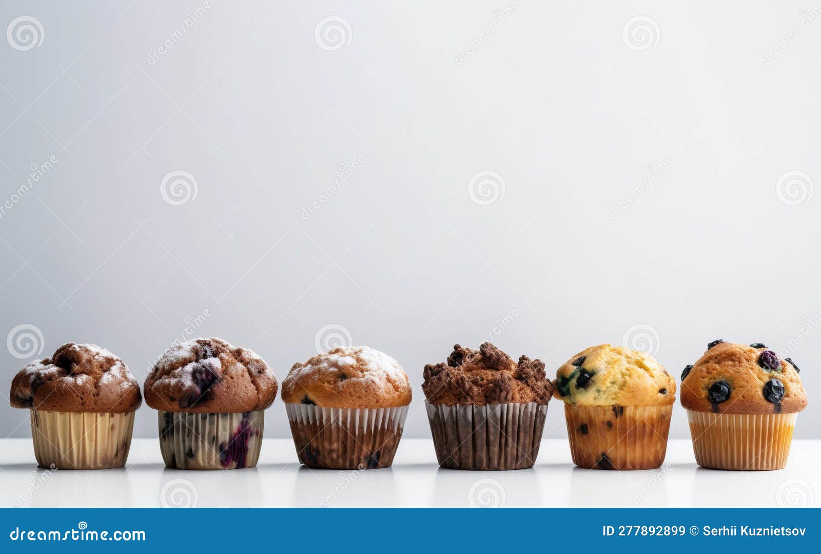 A Collection of Various Flour Muffins in a Row, White Background ...