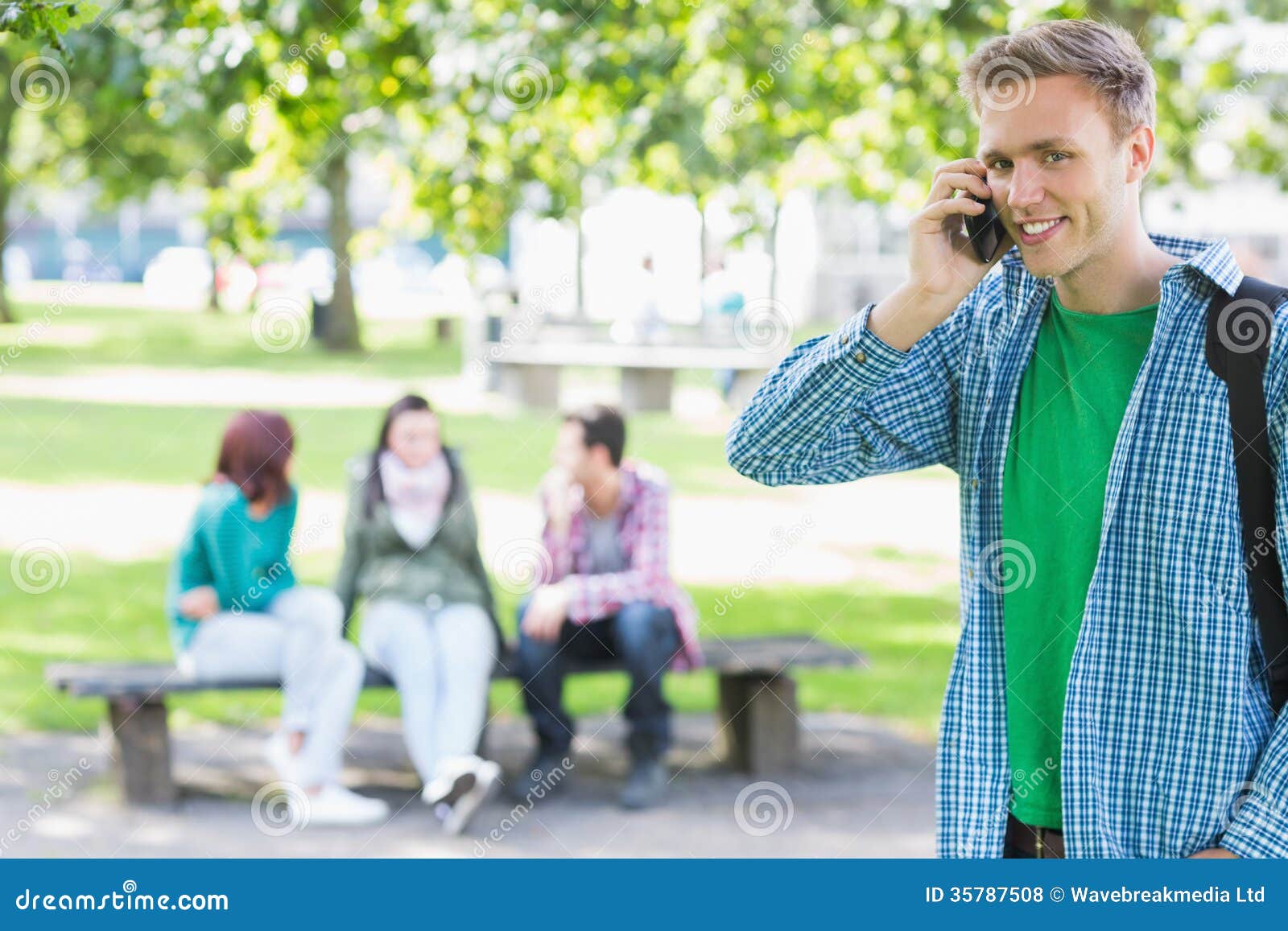 College Boy Using Mobile Phone with Students in Park Stock Photo ...