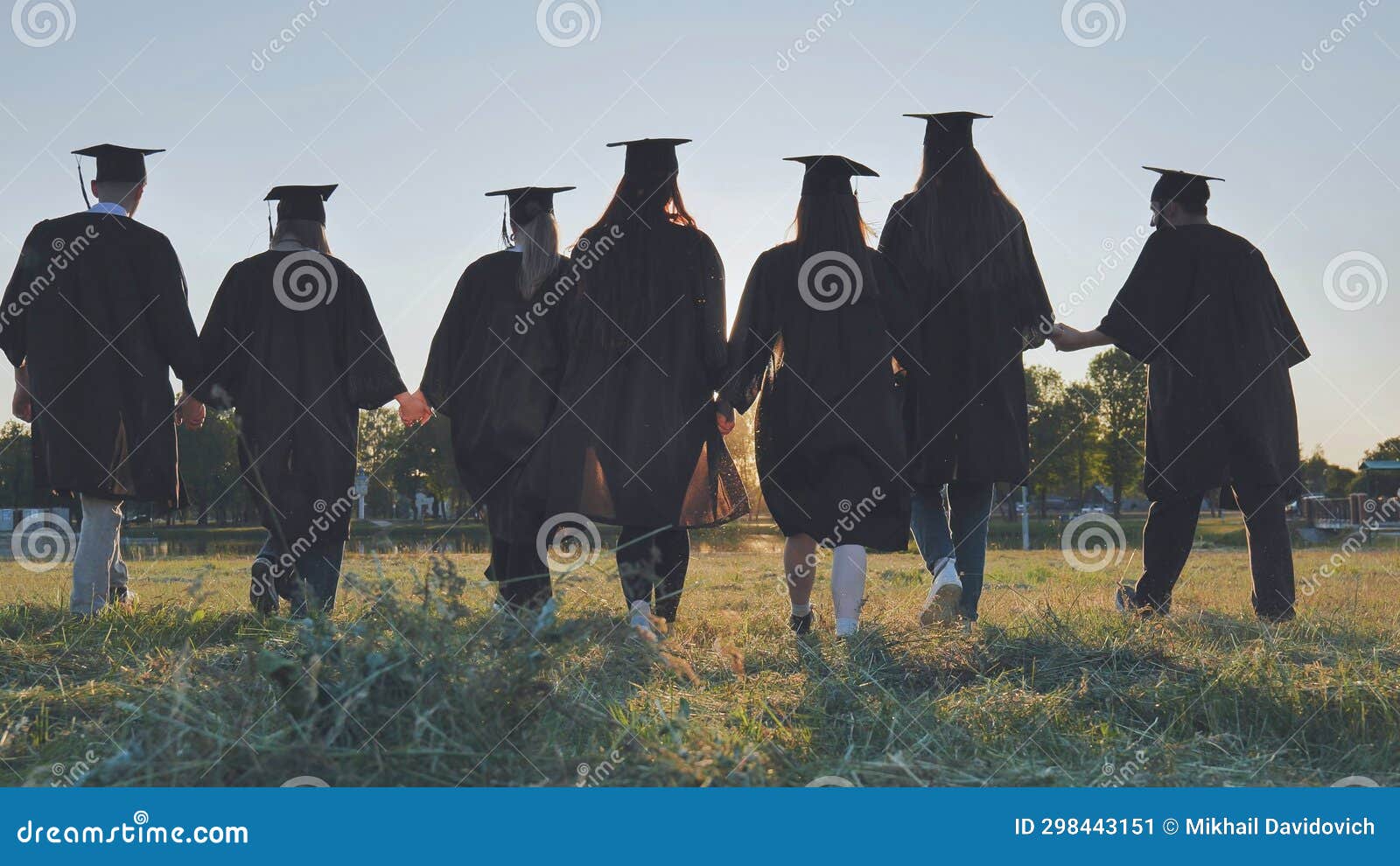 College Graduates Walk at Sunset Holding Hands. Stock Image - Image of ...