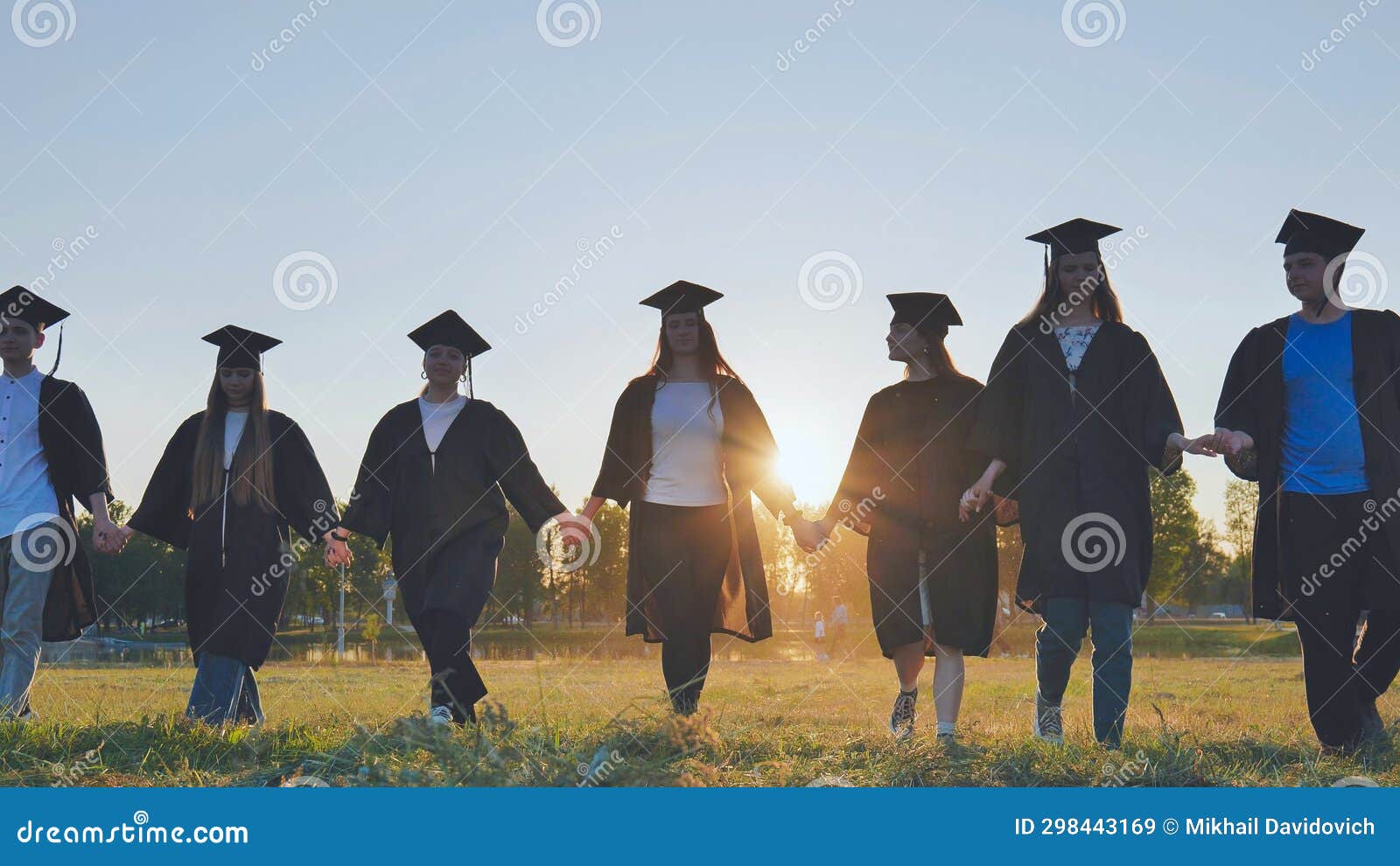 College Graduates Walk at Sunset Holding Hands. Stock Image - Image of ...