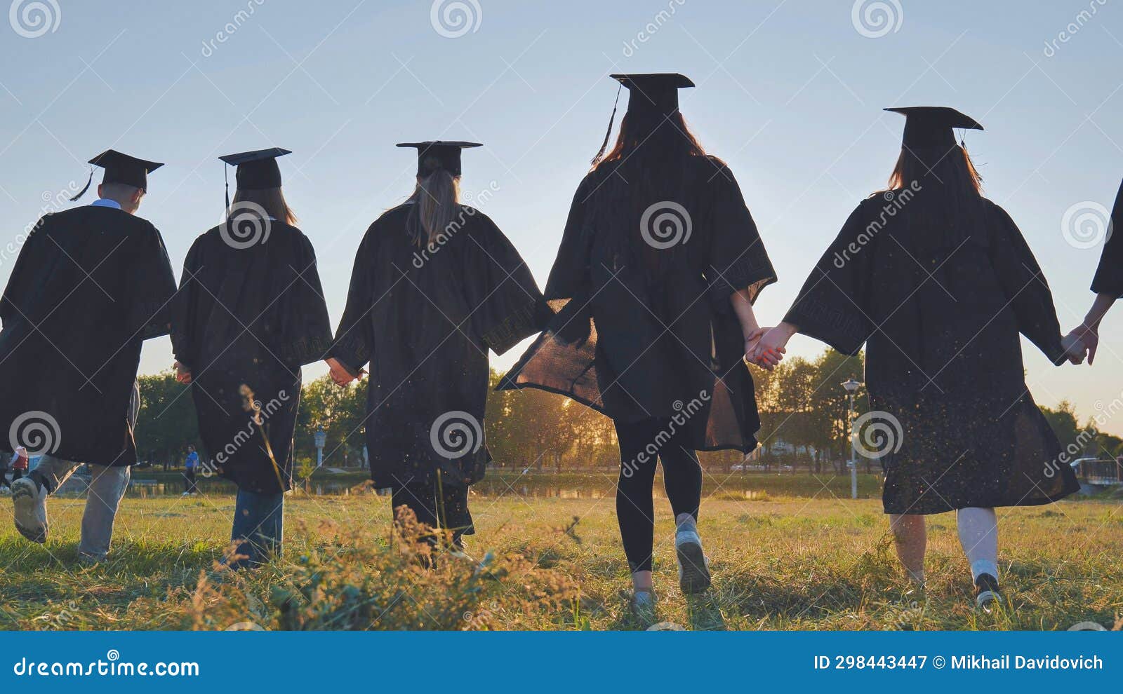 College Graduates Walk at Sunset Holding Hands. Stock Image - Image of ...