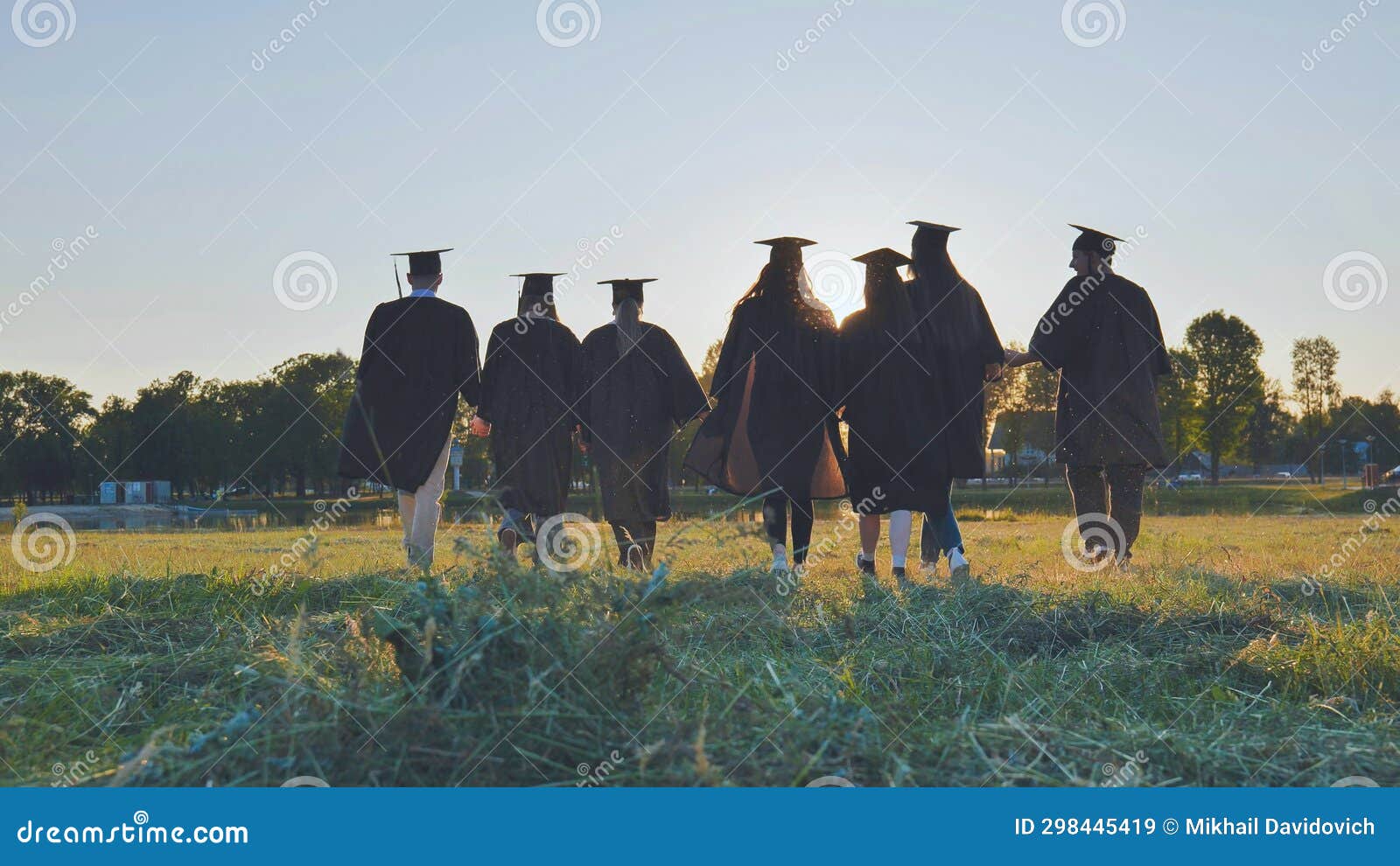 College Graduates Walk at Sunset Holding Hands. Stock Image - Image of ...