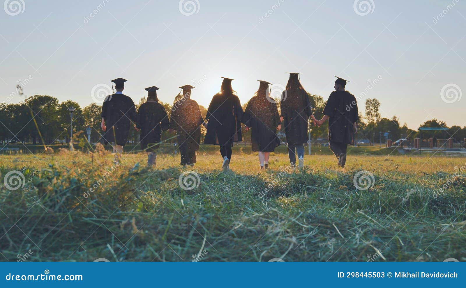 College Graduates Walk at Sunset Holding Hands. Stock Image - Image of ...