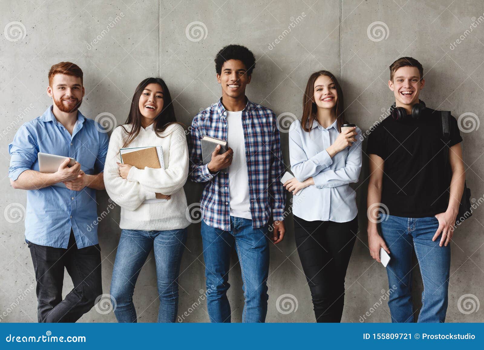 College Students with Books Smiling To Camera Over Grey Wall Stock ...