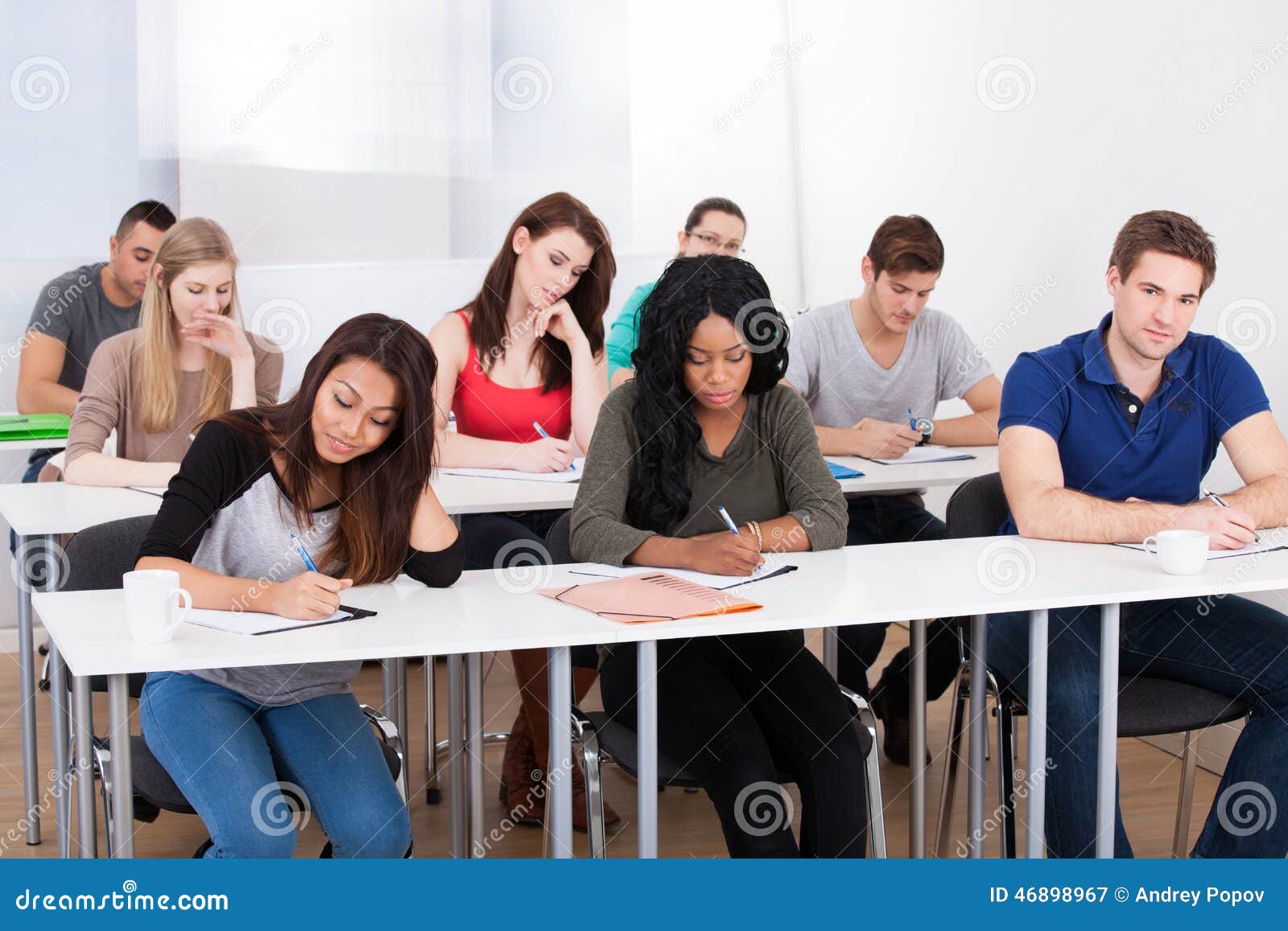 College Students Writing at Desk Stock Image - Image of indoors ...