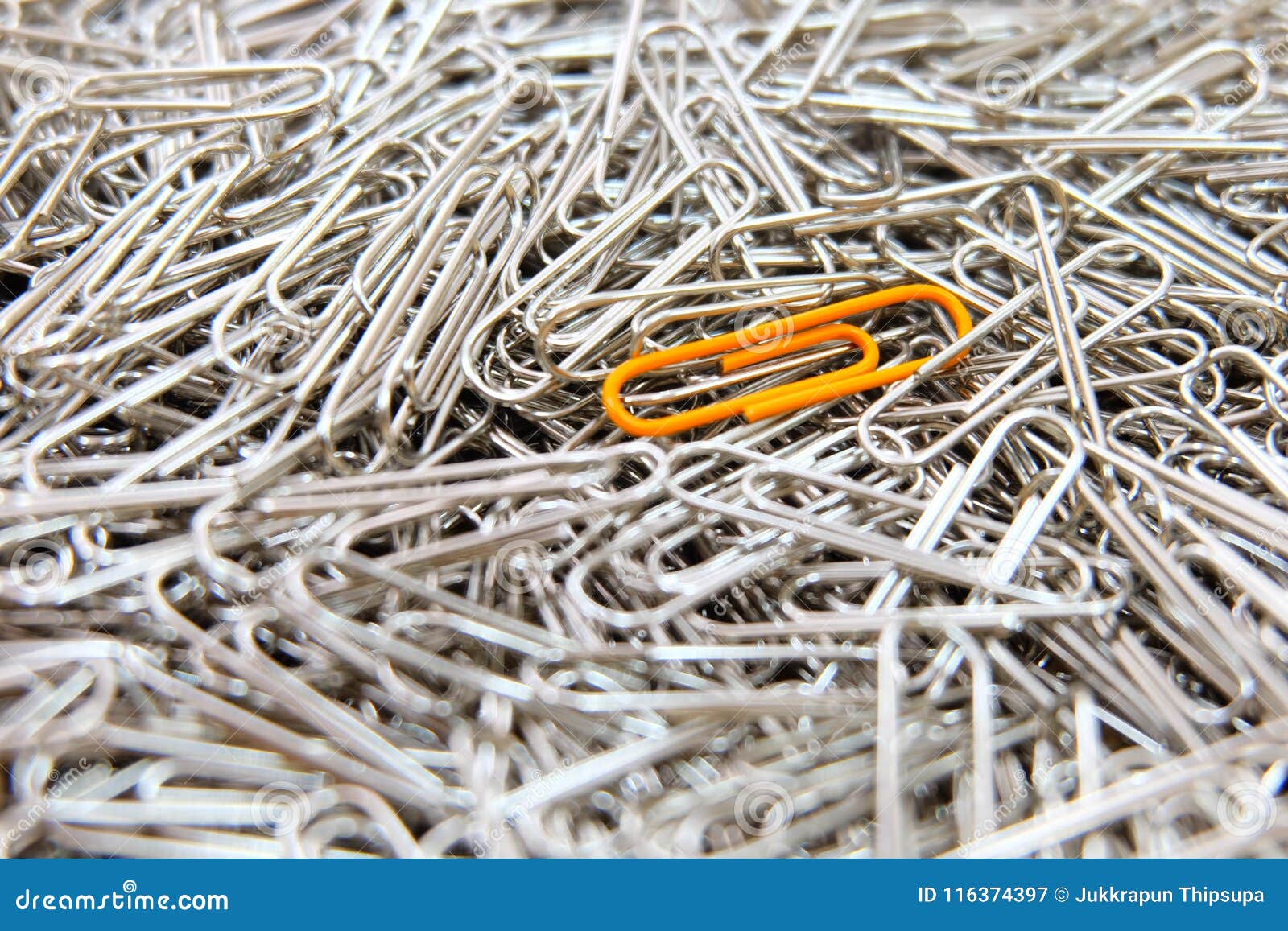 Orange Paper Clip on Multiple Paper Clips Background. Stock Image ...