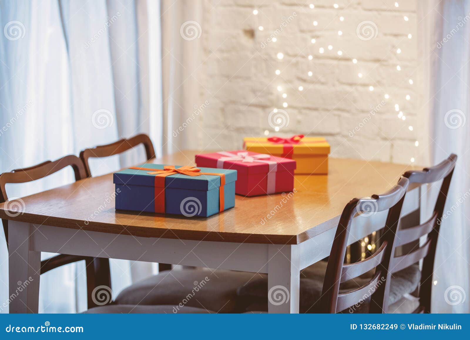Colored Gift Boxes on Table with Christmas Lights Stock Image - Image ...