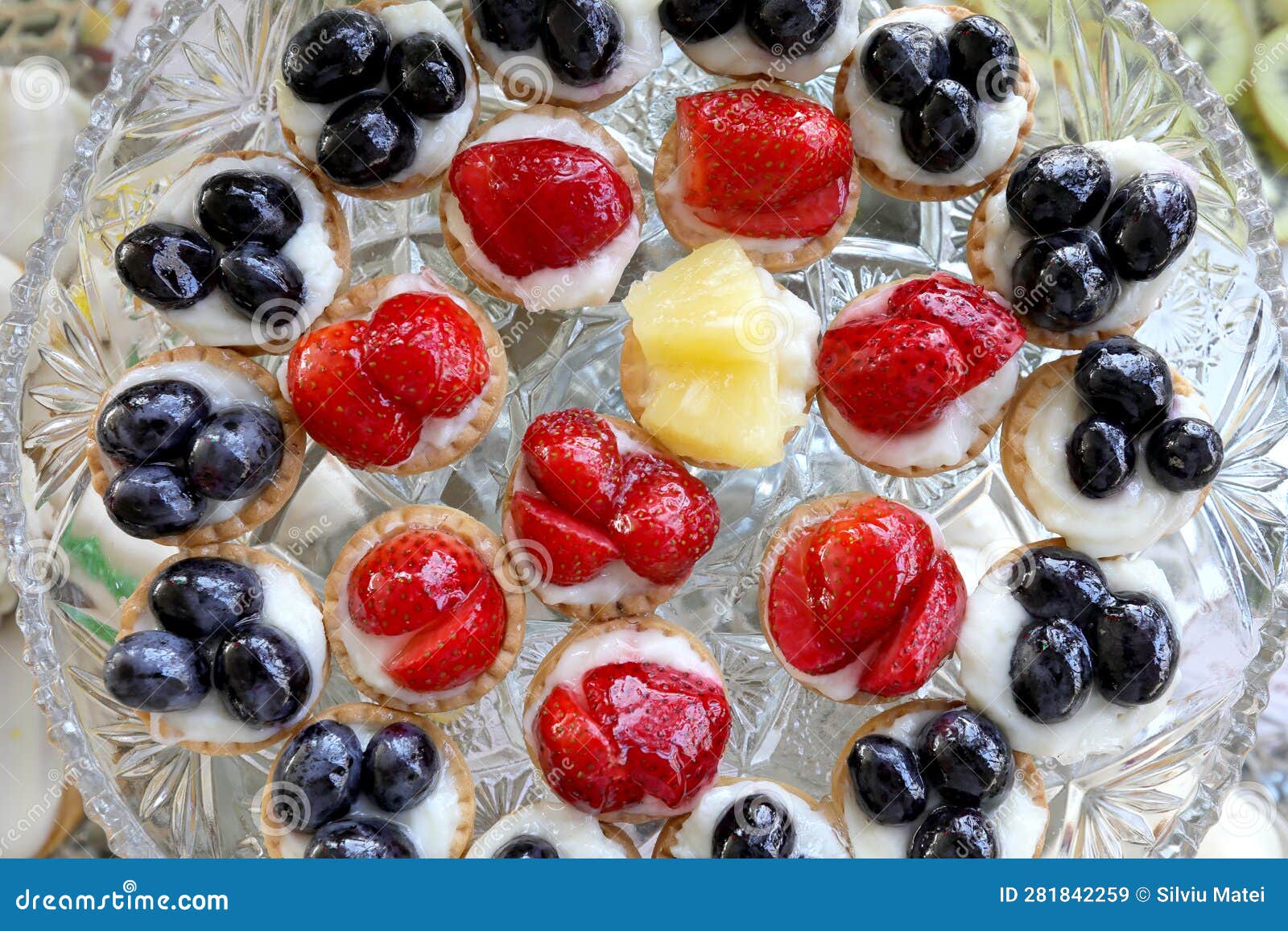 Colored Mini Tarts with Strawberry, Ananas and Grapes on a Table. Stock ...