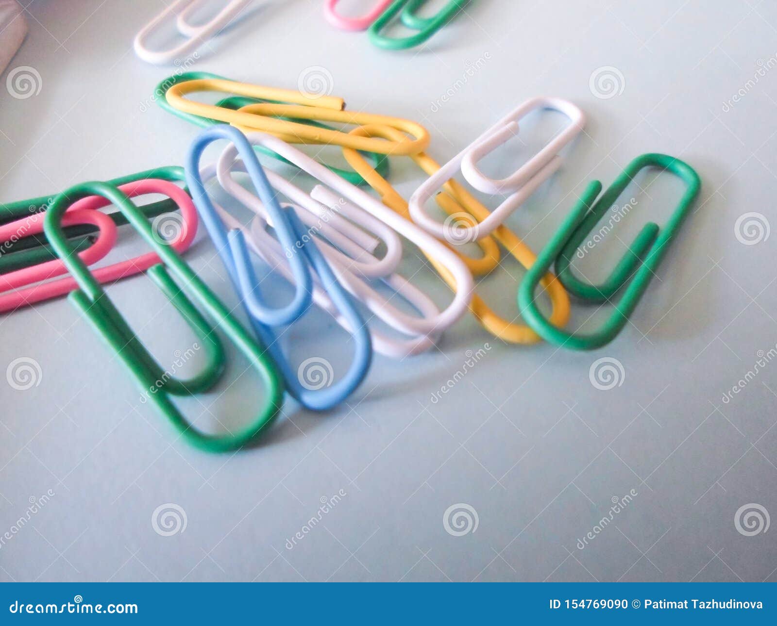 Colored Paper Clips on a White Sheet of Paper Scattered. Side View ...