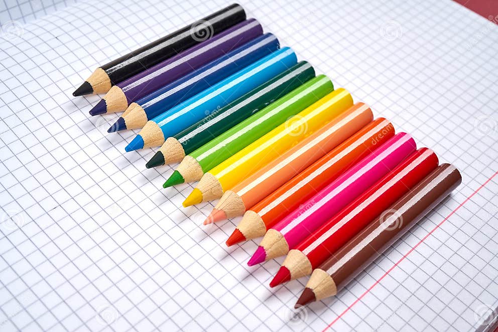 Colored Pencil Crayons on an Open Checkered Notebook Stock Image ...