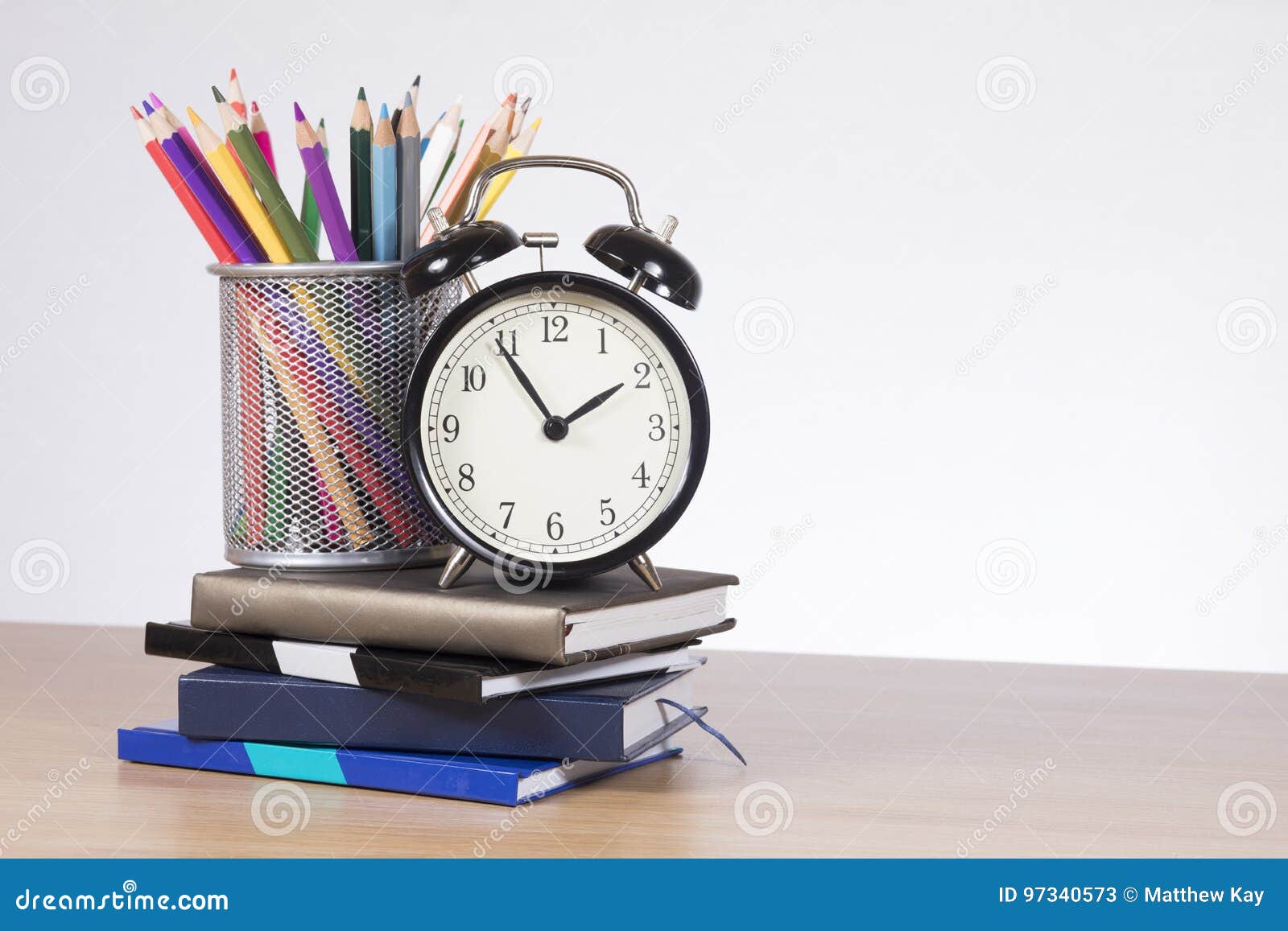 Colored Pencils and Alarm Clock Standing on Books Stock Image - Image ...