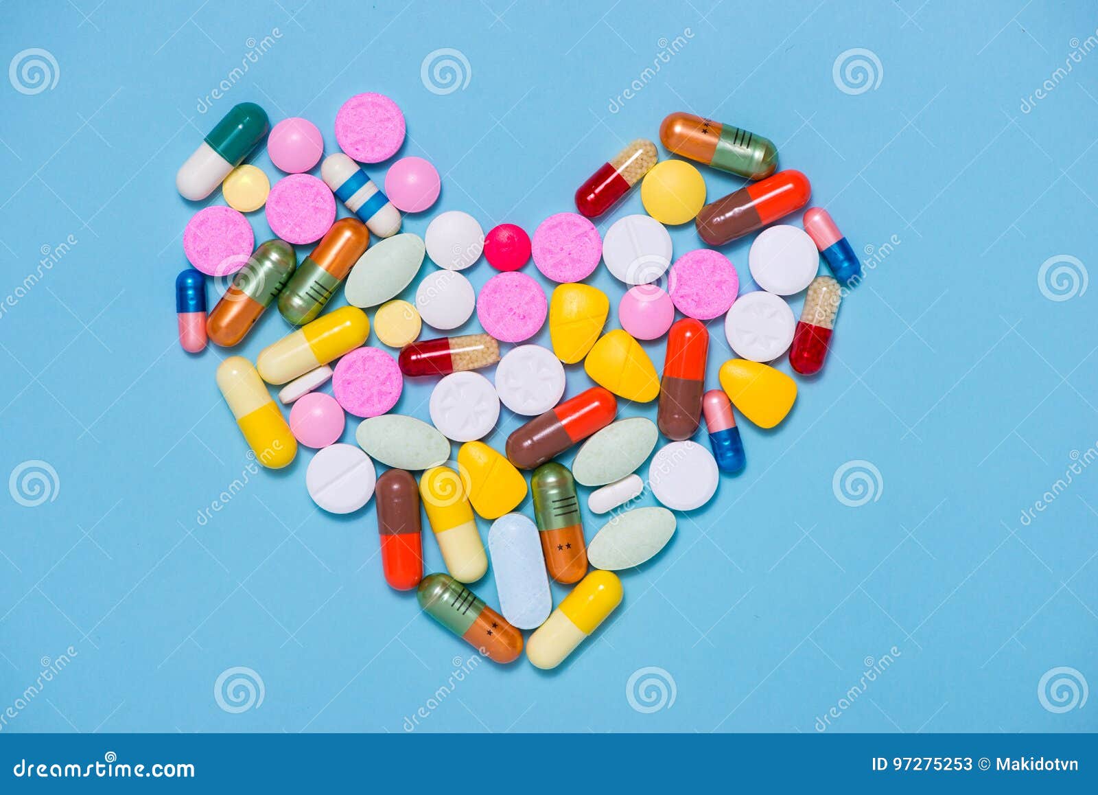 Colored Pills in Heart Shape on Blue Background. Stock Image - Image of ...