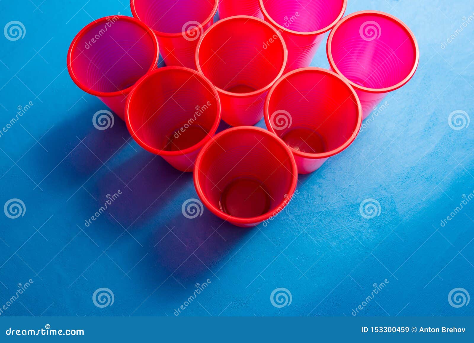 Colored Plastic Cups are a Triangle on a Blue Background. Composition ...