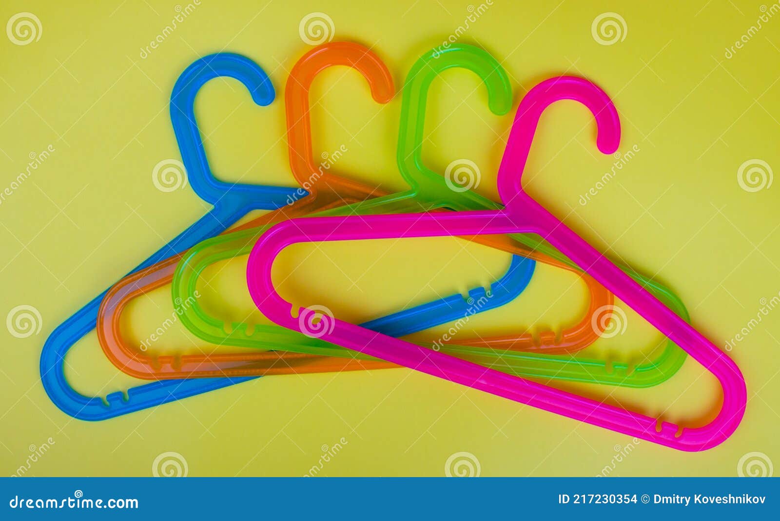 Colored Plastic Hangers on Yellow Background. Storage and Sales Concept ...