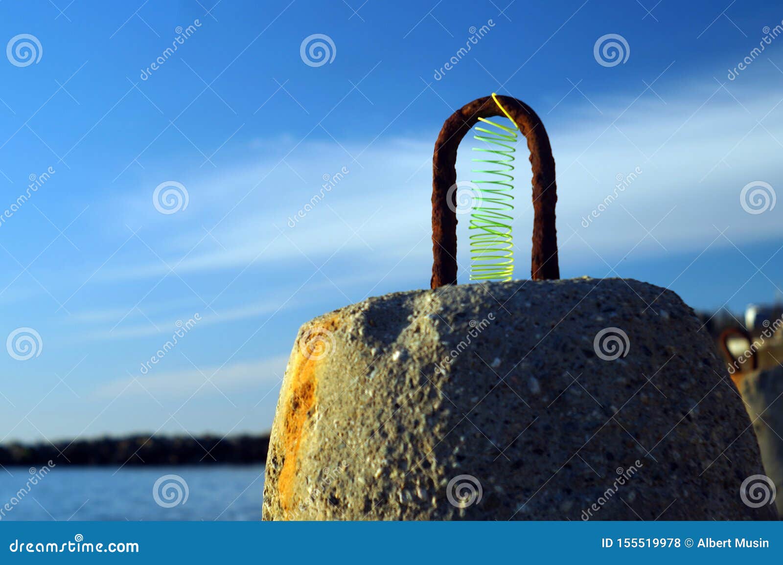Colored Plastic Spring on a Rusty Loop of Reinforced Concrete Shore ...