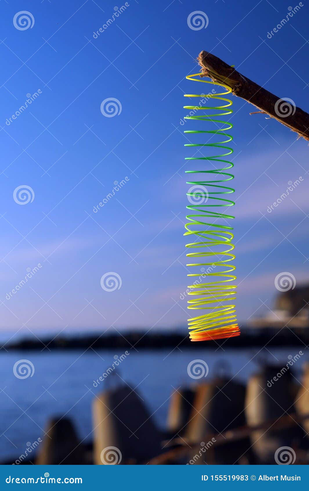 Colored Plastic Spring on a Rusty Loop of Reinforced Concrete Shore ...