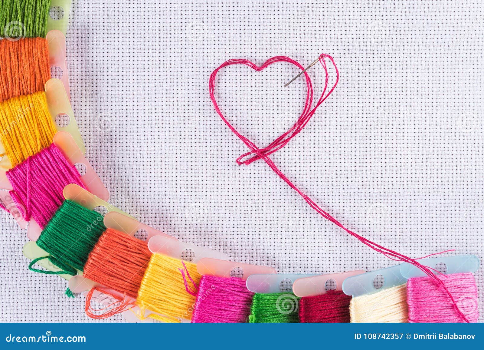 Colored Thread for Embroidery on White Canvas, a Needle with Red Thread ...