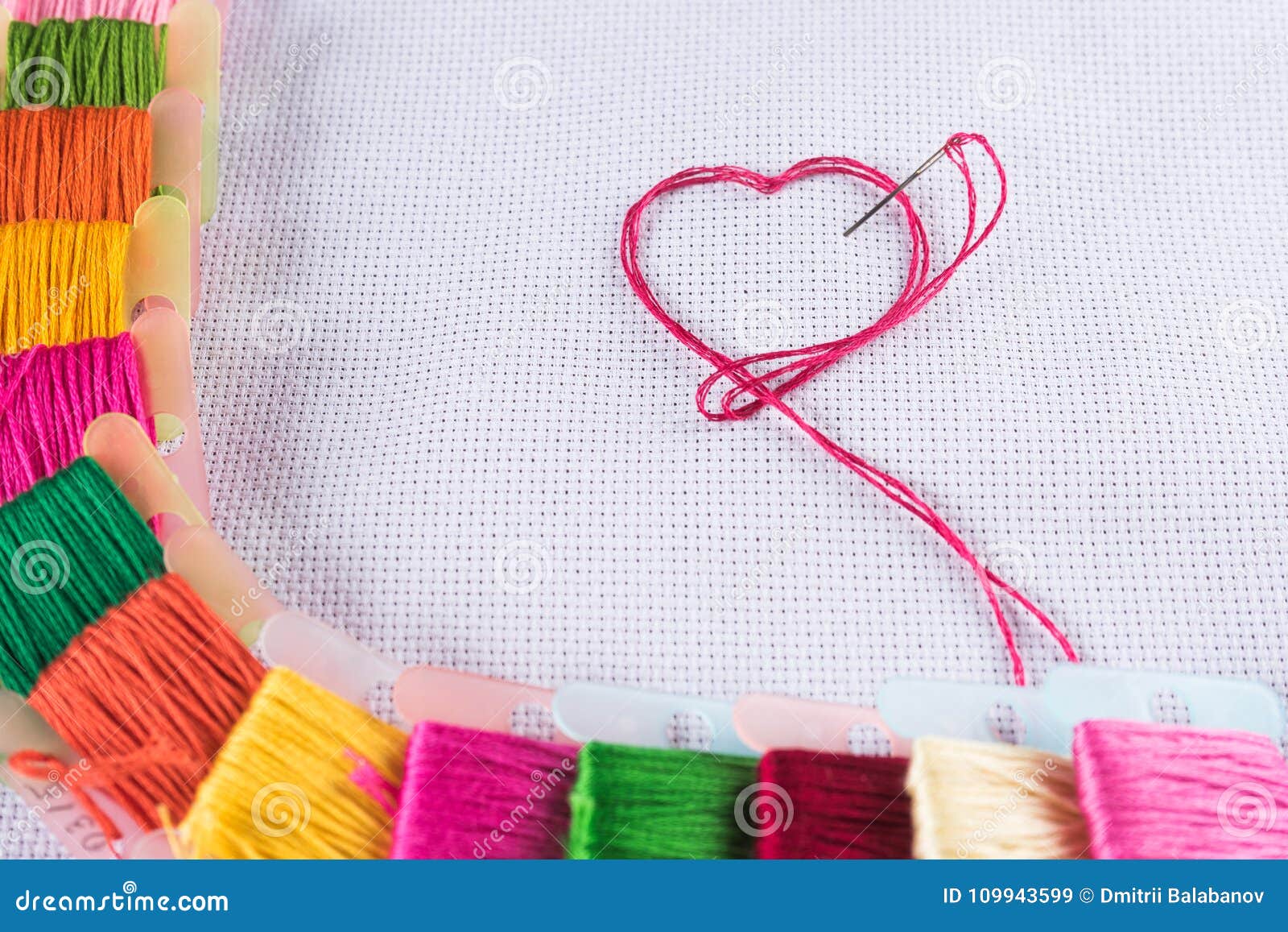 Colored Thread for Embroidery on White Canvas, a Needle with Red Thread ...