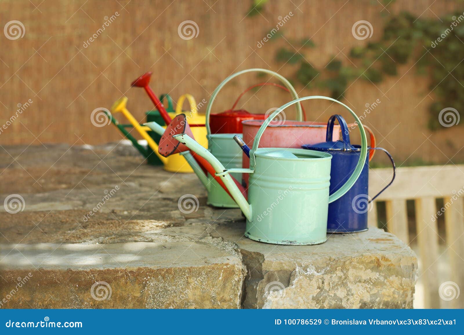 Colored watering cans stock image. Image of wall, summer - 100786529