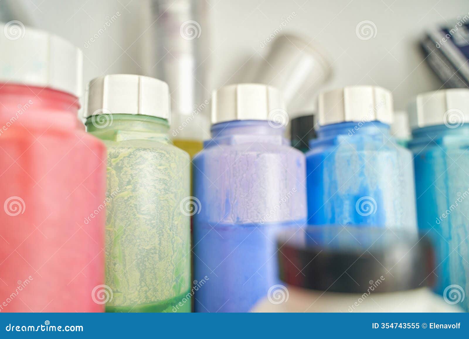 Colorful Array of Plastic Paint Bottles in a Row on Shelf Closeup with ...