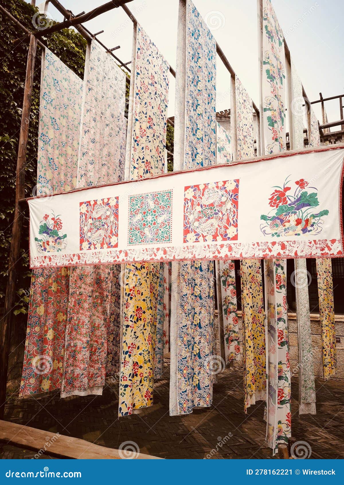 Colorful Array of Silk Fabrics Hanging from Wooden Poles in a Vibrant ...