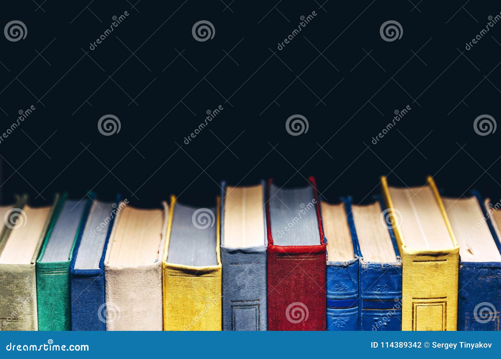 Colorful Books in a Row in Library or Bookstore on Black Background ...