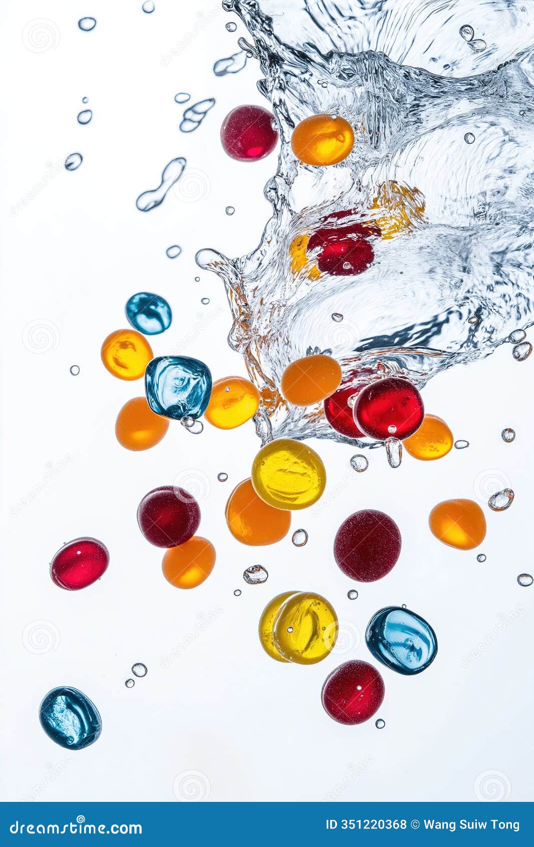 Colorful Candies Splashing into Water Creating Bubbles Stock ...