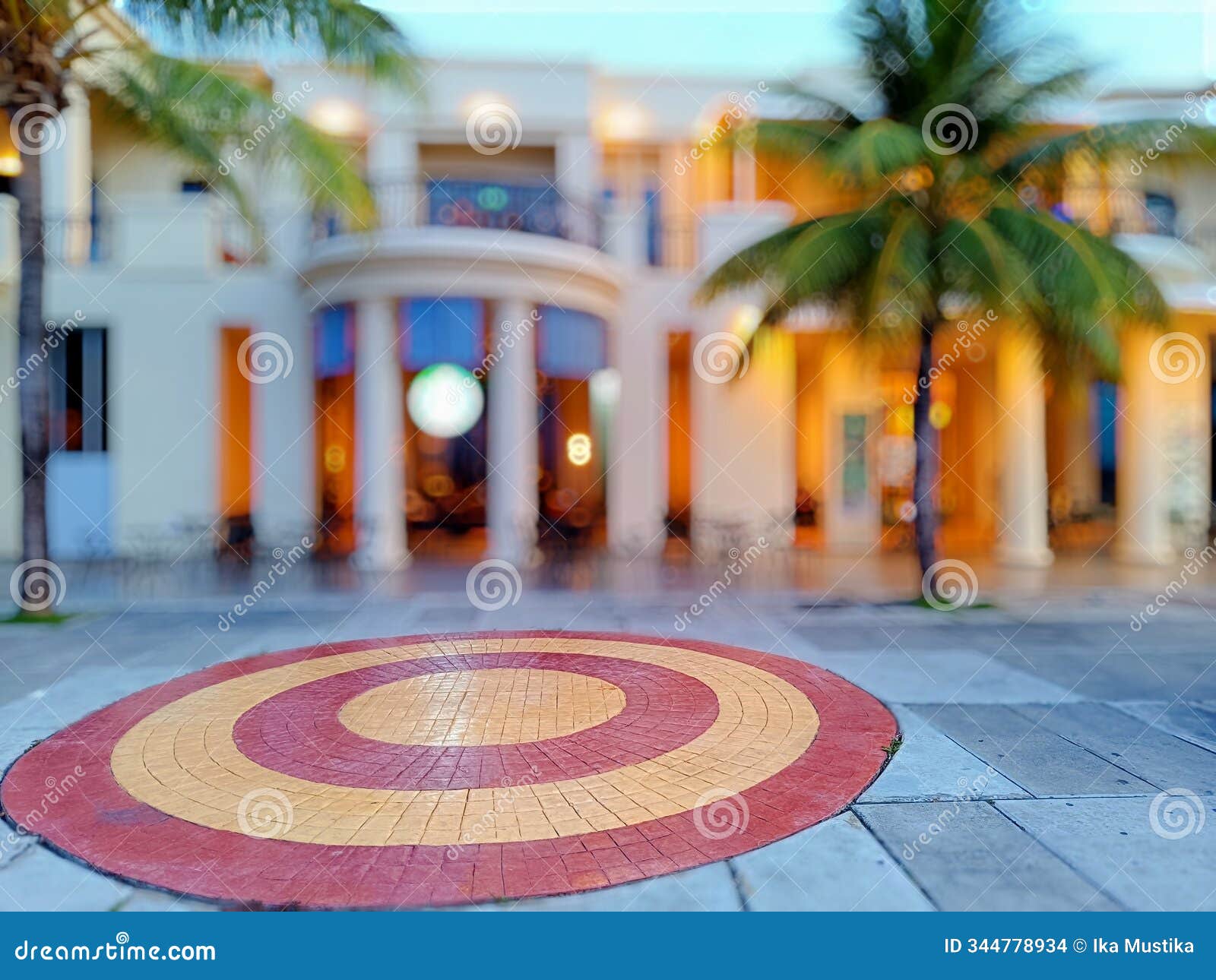 A Colorful Circular Pattern on a Tiled Walkway, with Blurry Beachfront ...