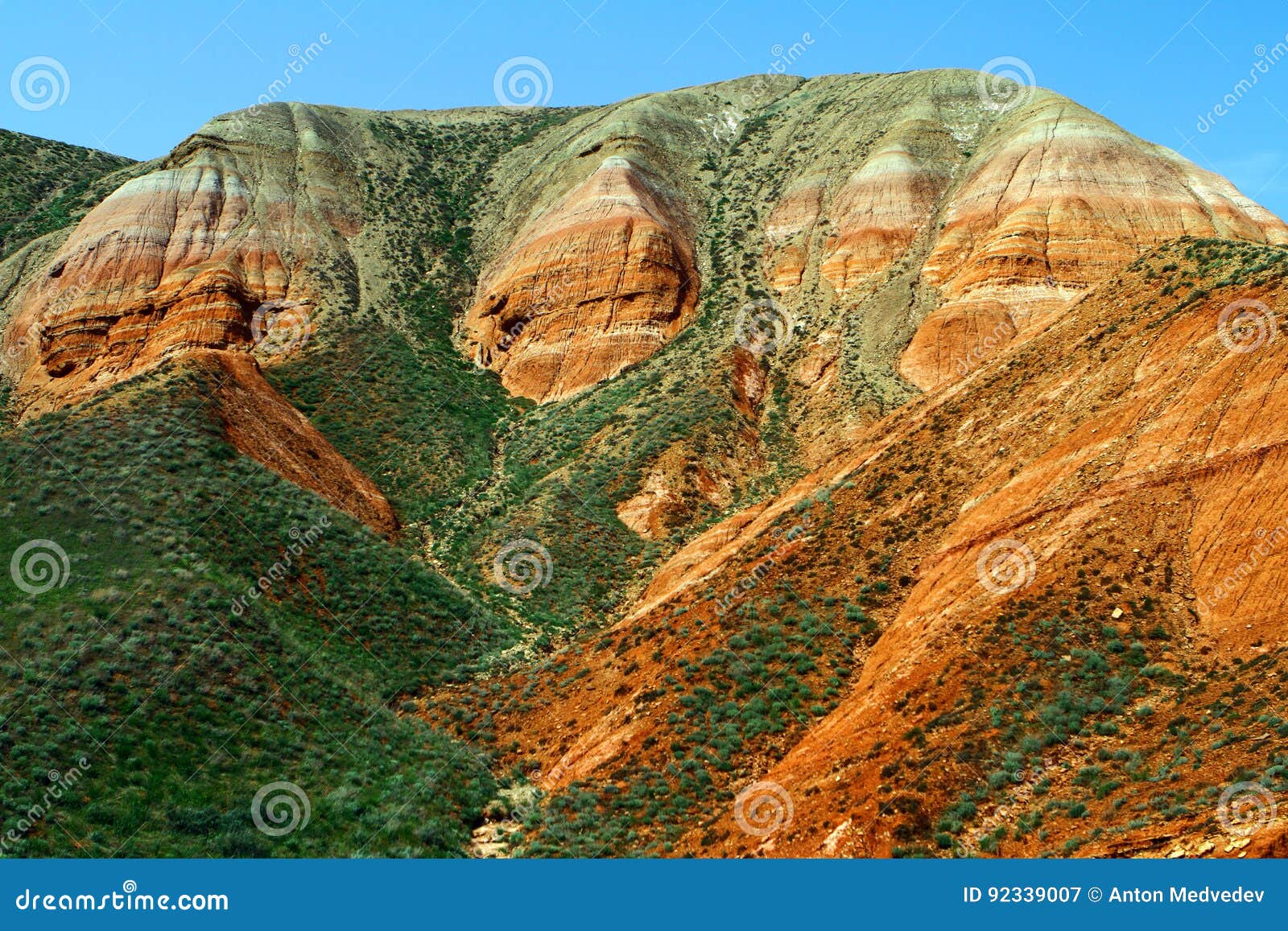 Colorful Eroded Cliffs with the Green Grassy Slope Stock Image - Image ...