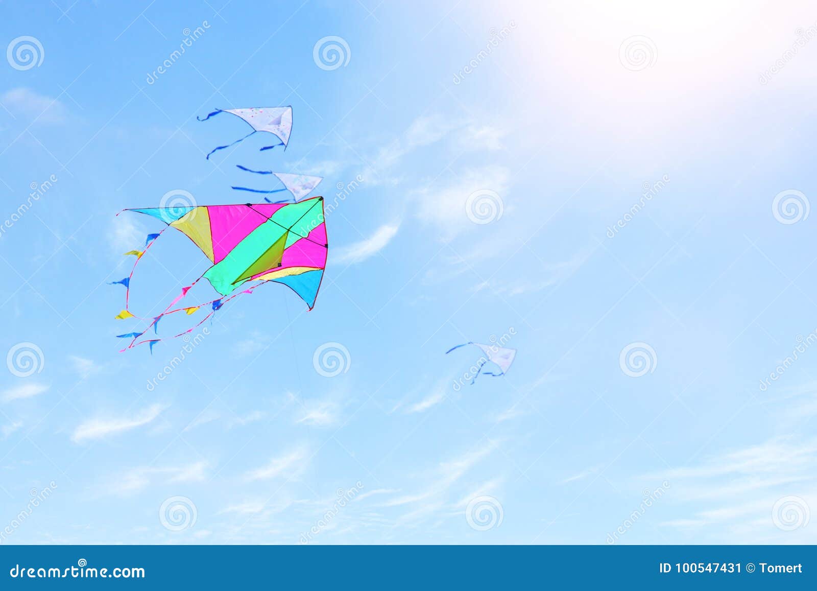 Colorful Kite Flying in the Blue Sky through the Clouds. Stock Image ...