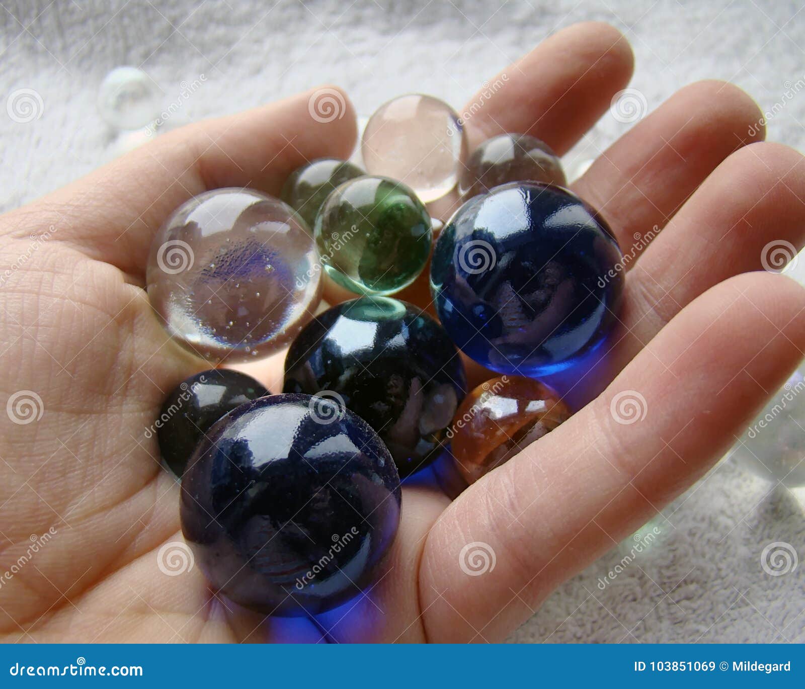 Colorful marbles in hand stock image. Image of body - 103851069