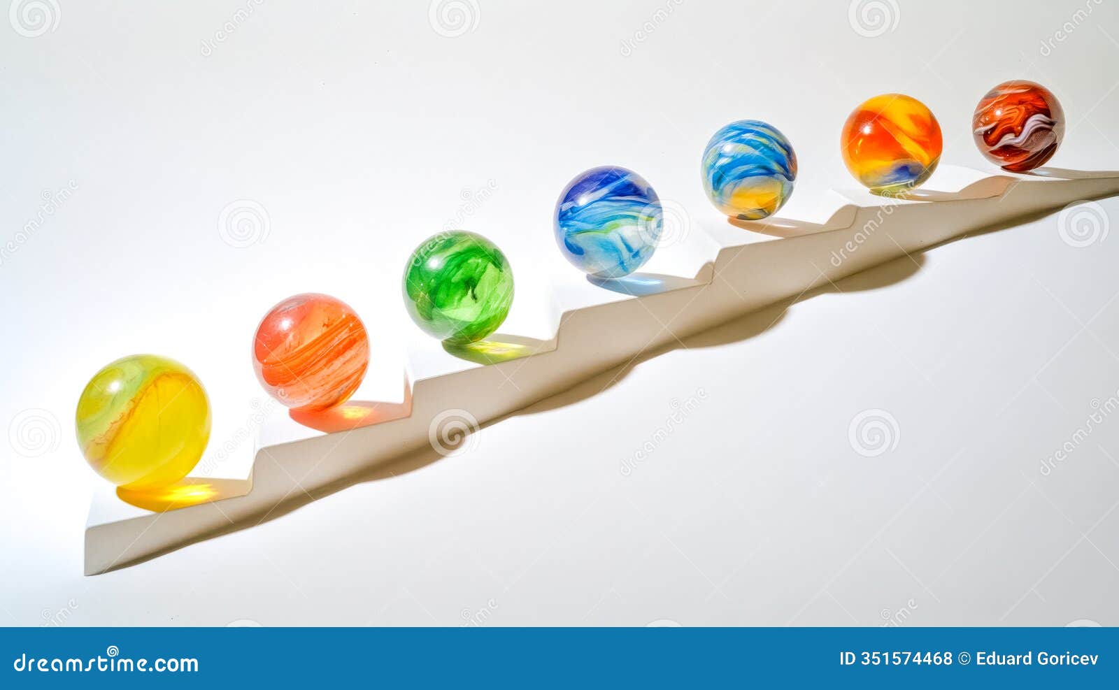 Colorful Marbles Rolling Down a White Slope in a Conceptual Image Stock ...