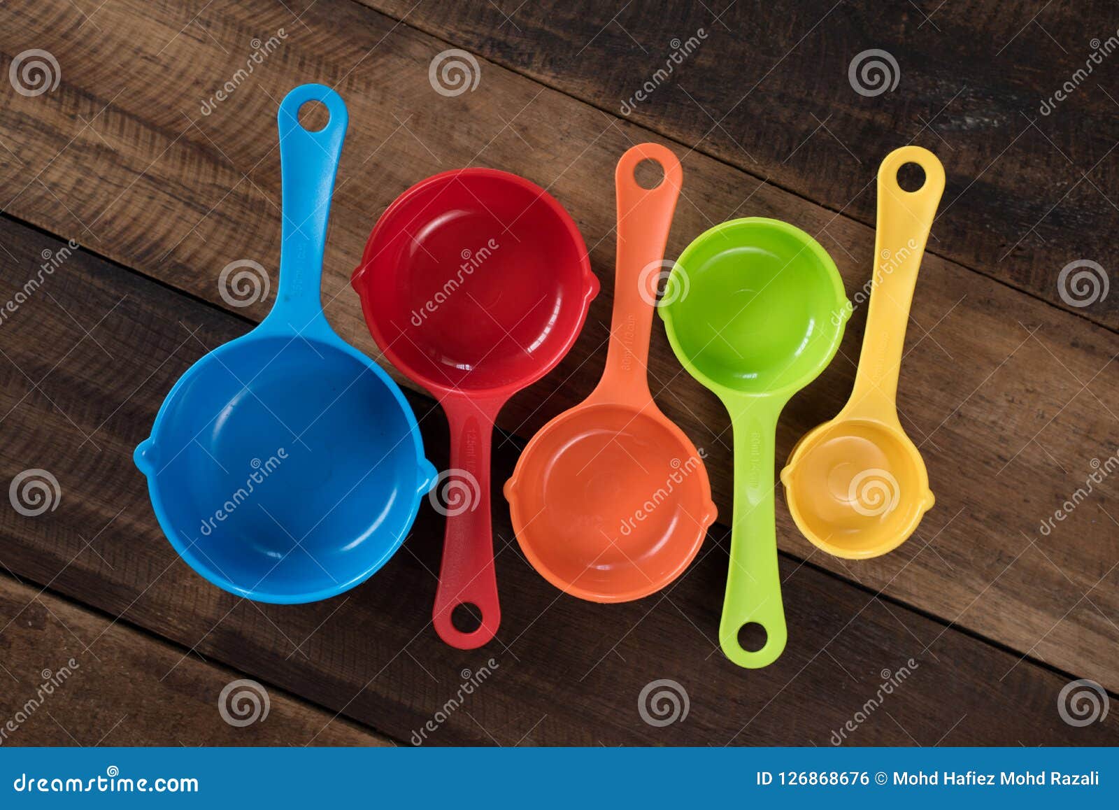 Colorful Measuring Spoons For Kitchen On A White Wooden Background ...