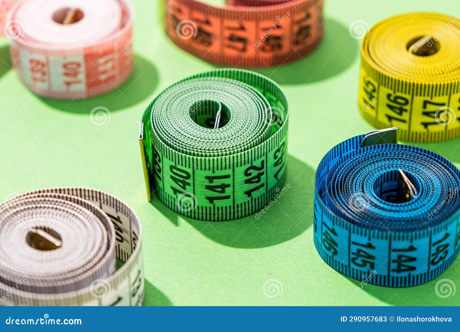 Colorful Measuring Tapes on Bright Green Background Stock Image - Image ...