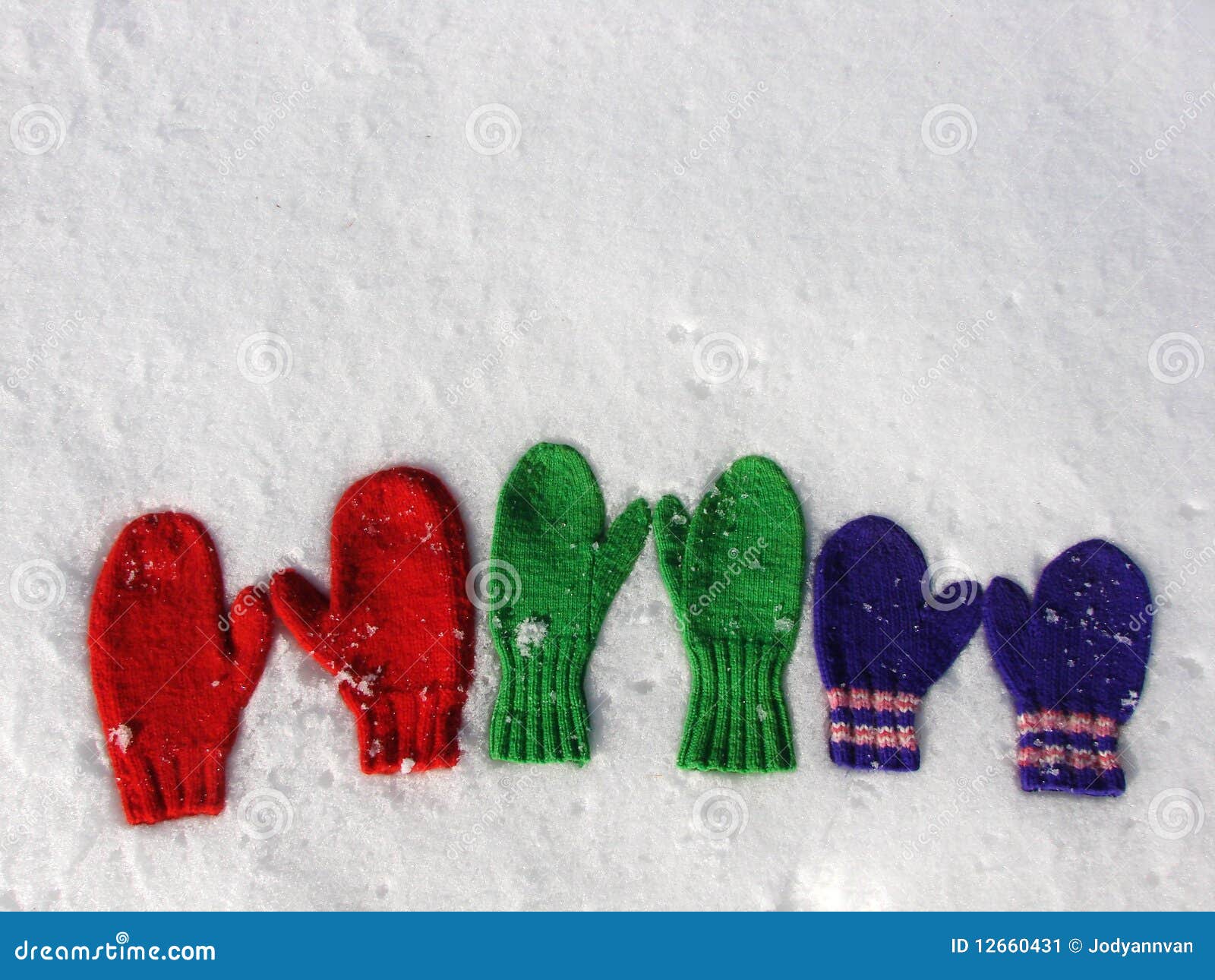 Colorful mittens on snow stock image. Image of hand, green - 12660431