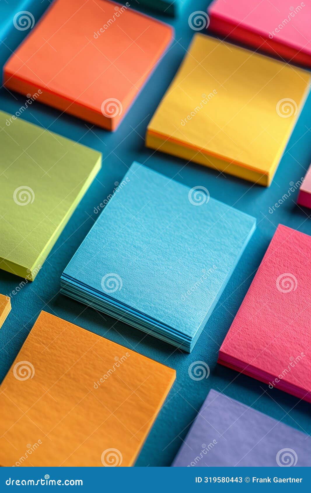 Colorful Paper Stacks and Sticky Notes Arranged Neatly Against a Blue ...