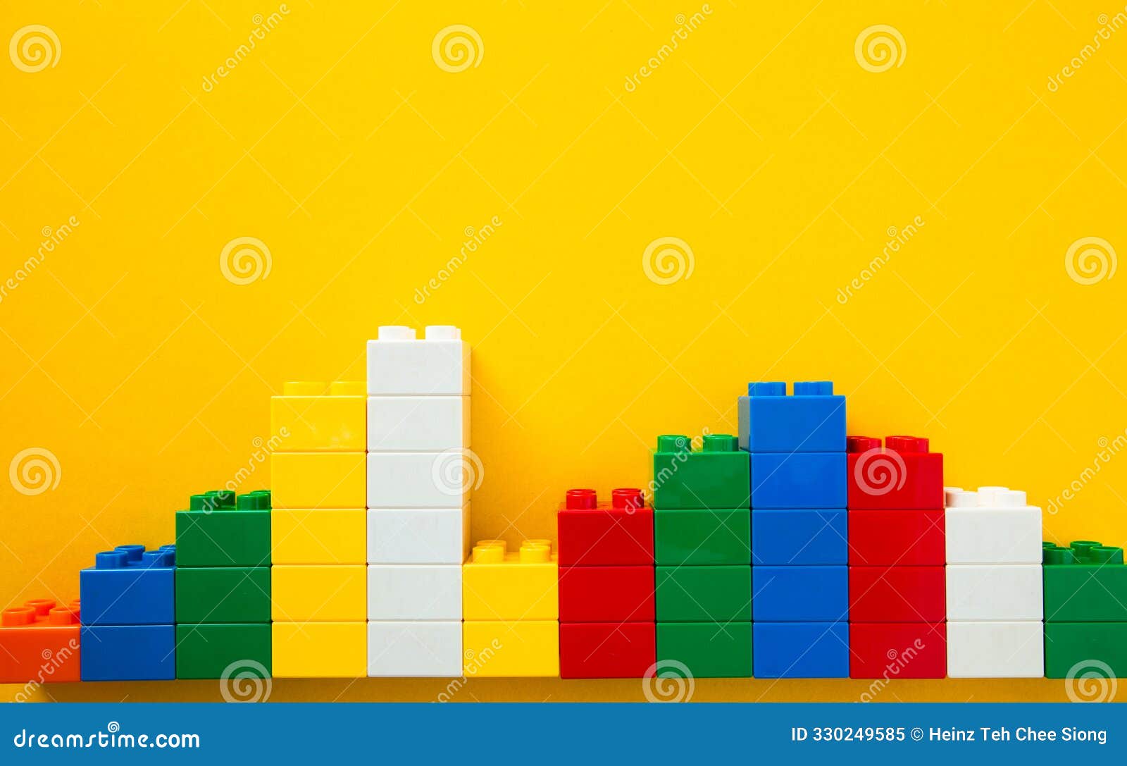 Colorful Plastic Building Blocks Creating Decreasing Graph on Yellow ...