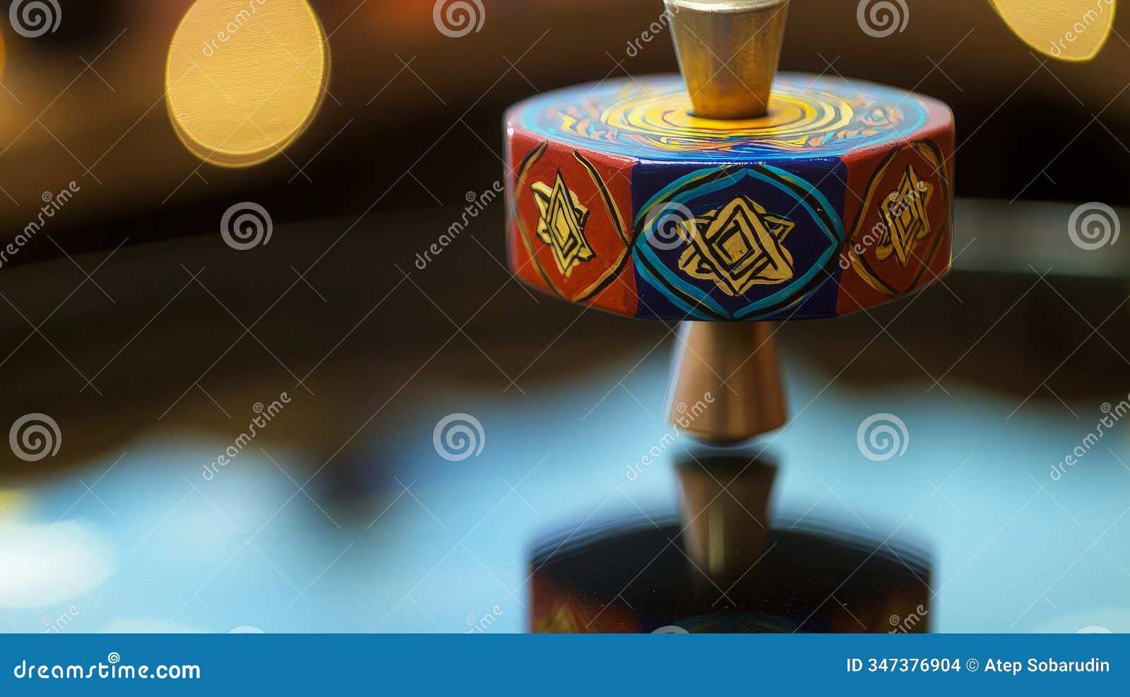 Colorful Spinning Top with Geometric Patterns on a Reflective Surface ...