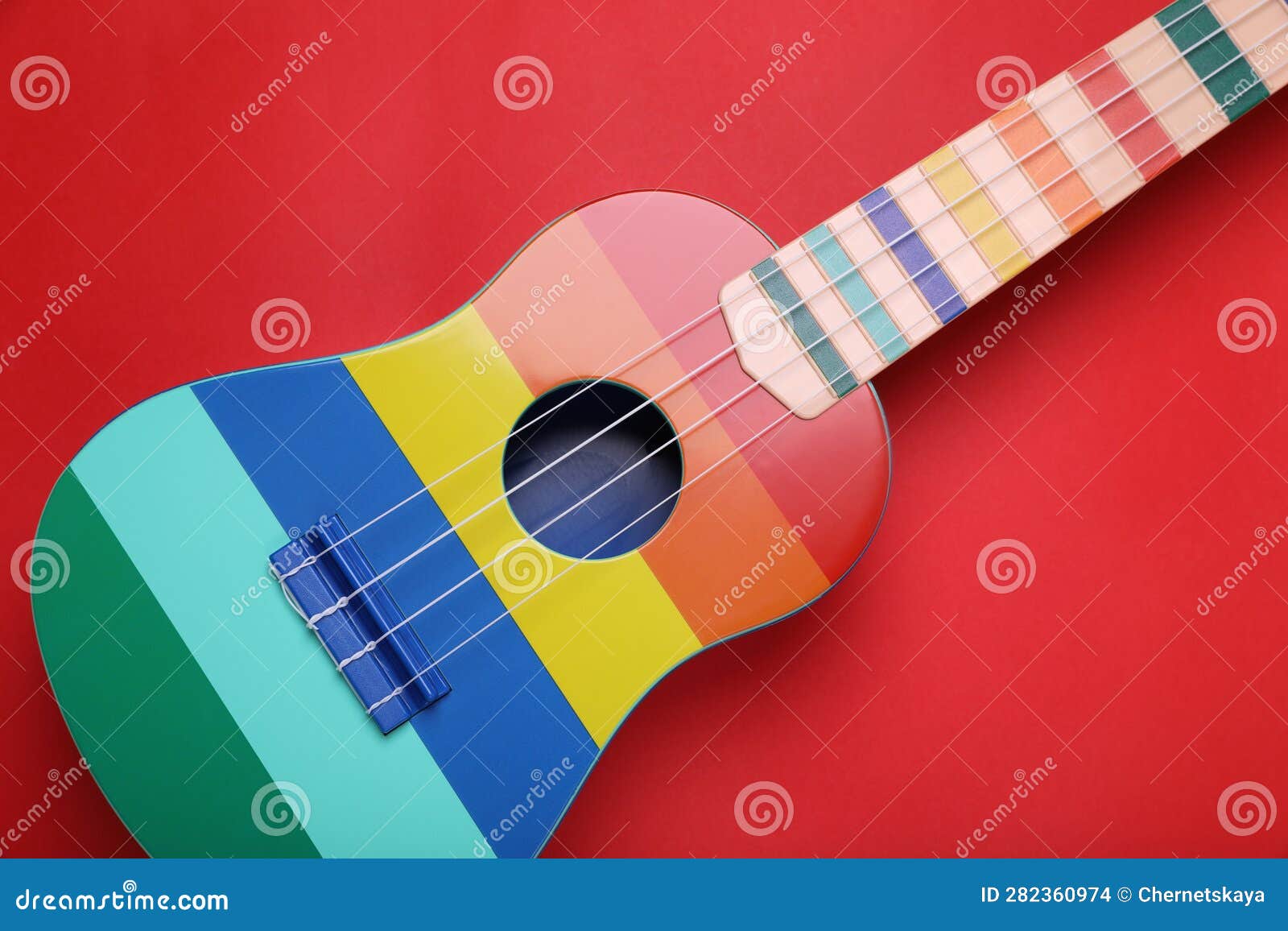 Colorful Ukulele on Red Background, Top View. String Musical Instrument ...