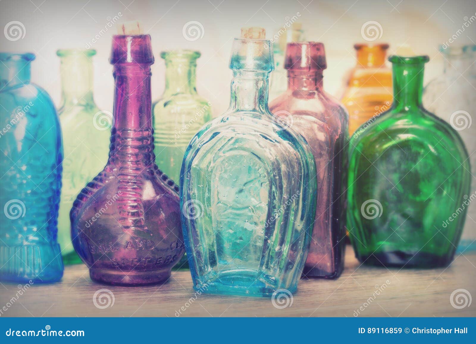 Coloured Glass Bottles on a Rustic Background Stock Image - Image of ...
