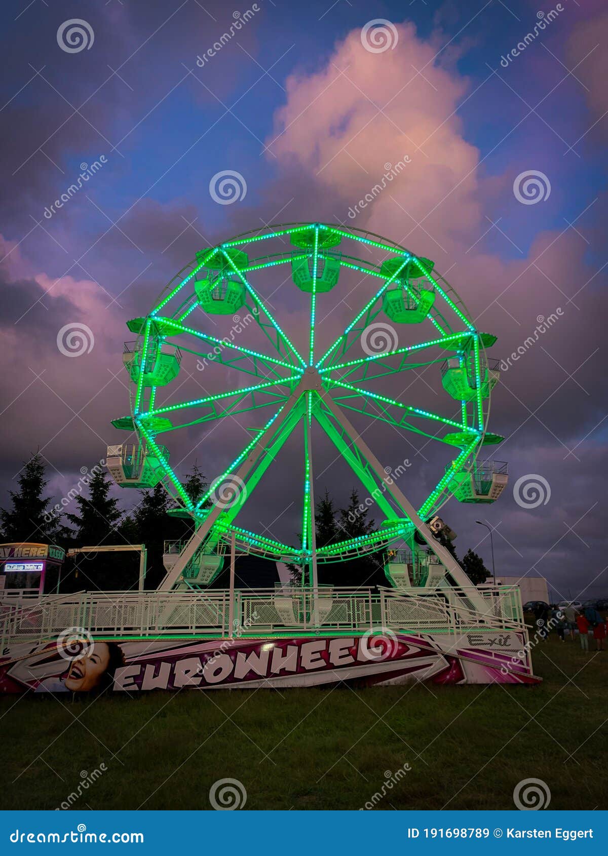 A Colourfully Illuminated Ferris Wheel Stands in Front of a Dark Sky ...