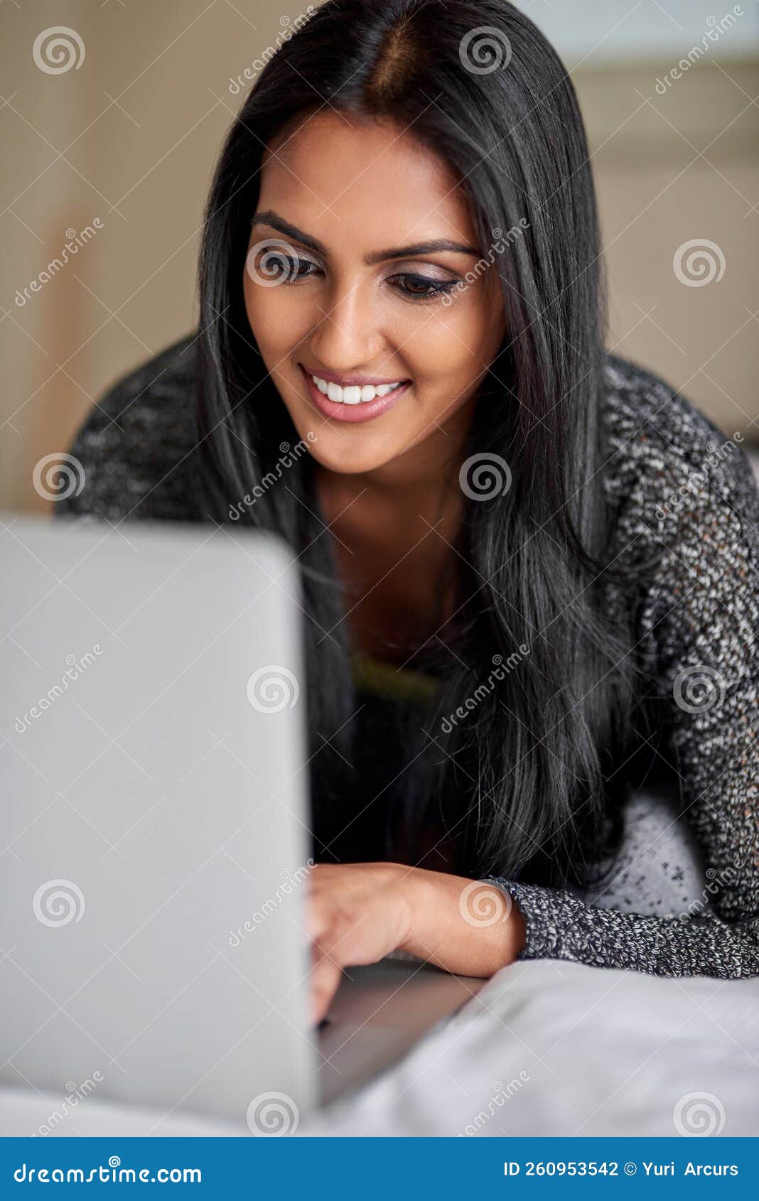 Comfy Computing. a Young Woman Relaxing on the Bed and Using a Laptop ...