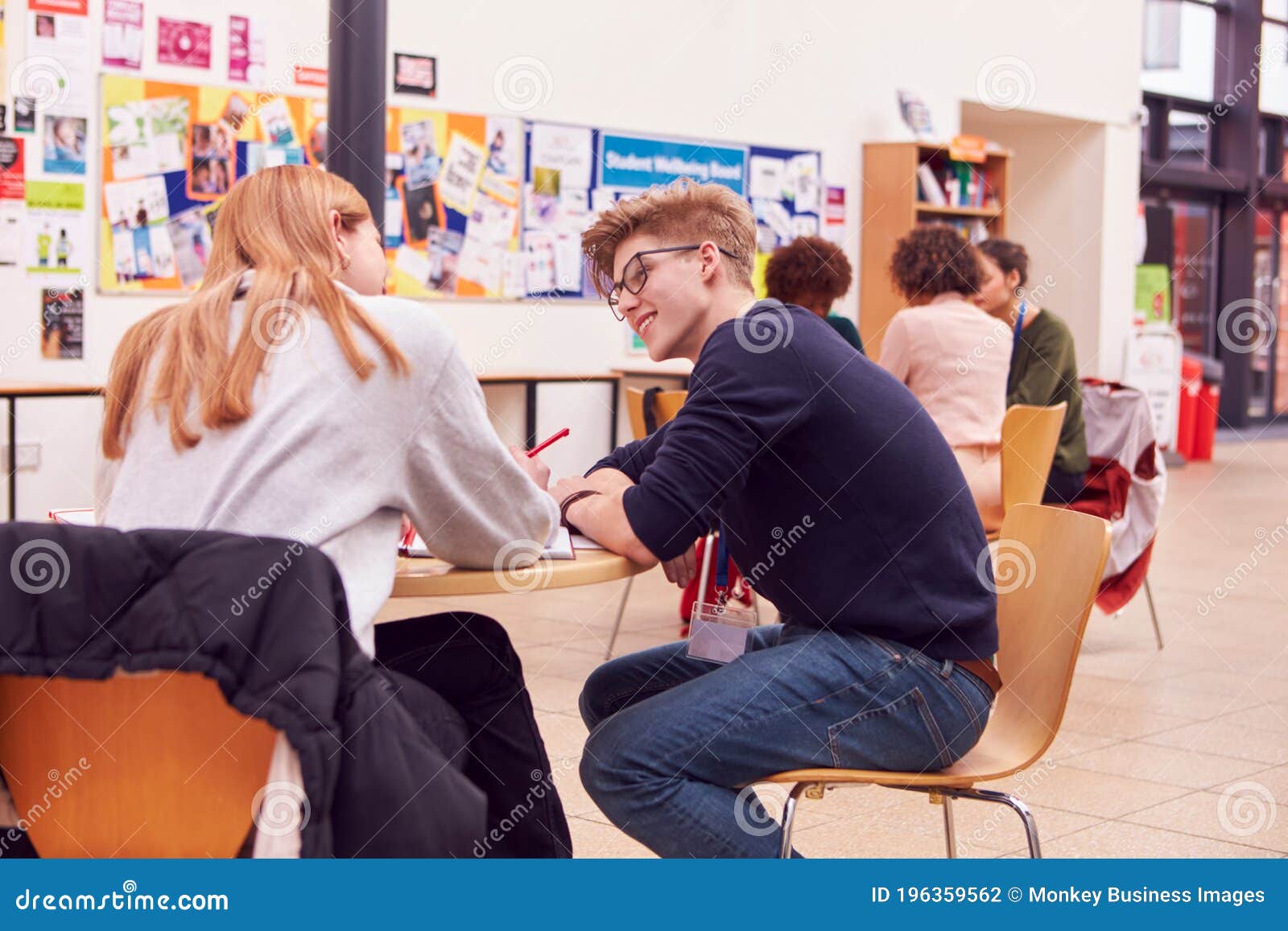 Communal Area of Busy College Campus with Students Working at Tables ...