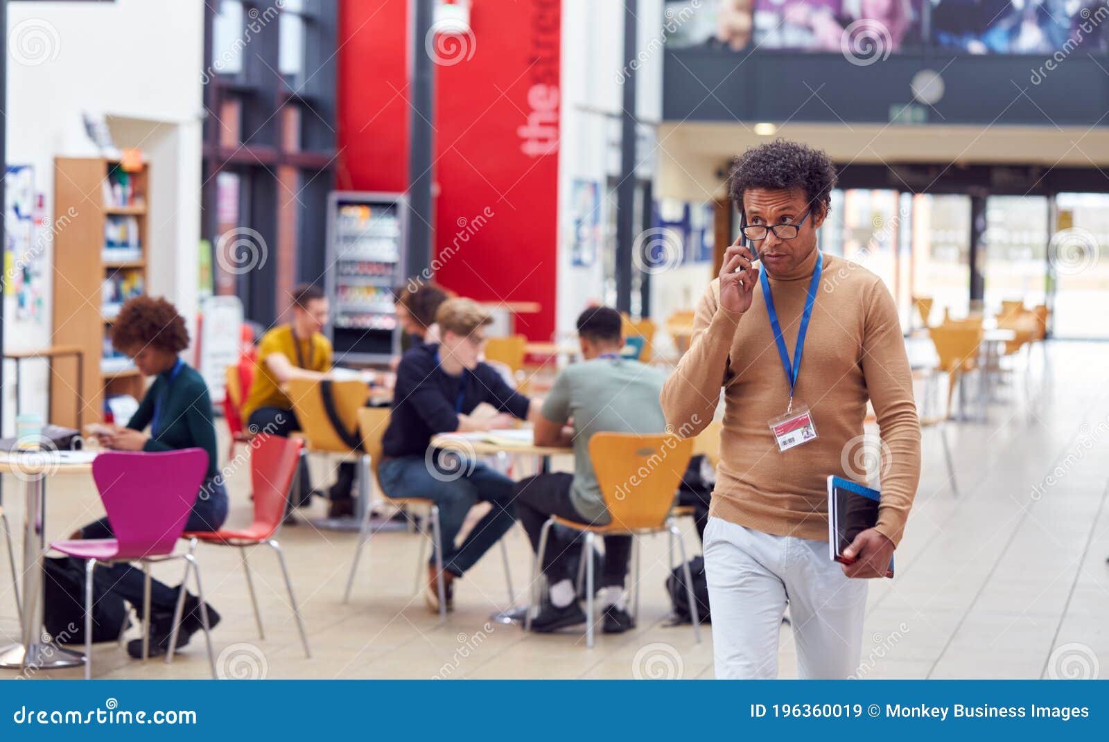 Communal Area of Busy College Campus with Students Working at Tables ...