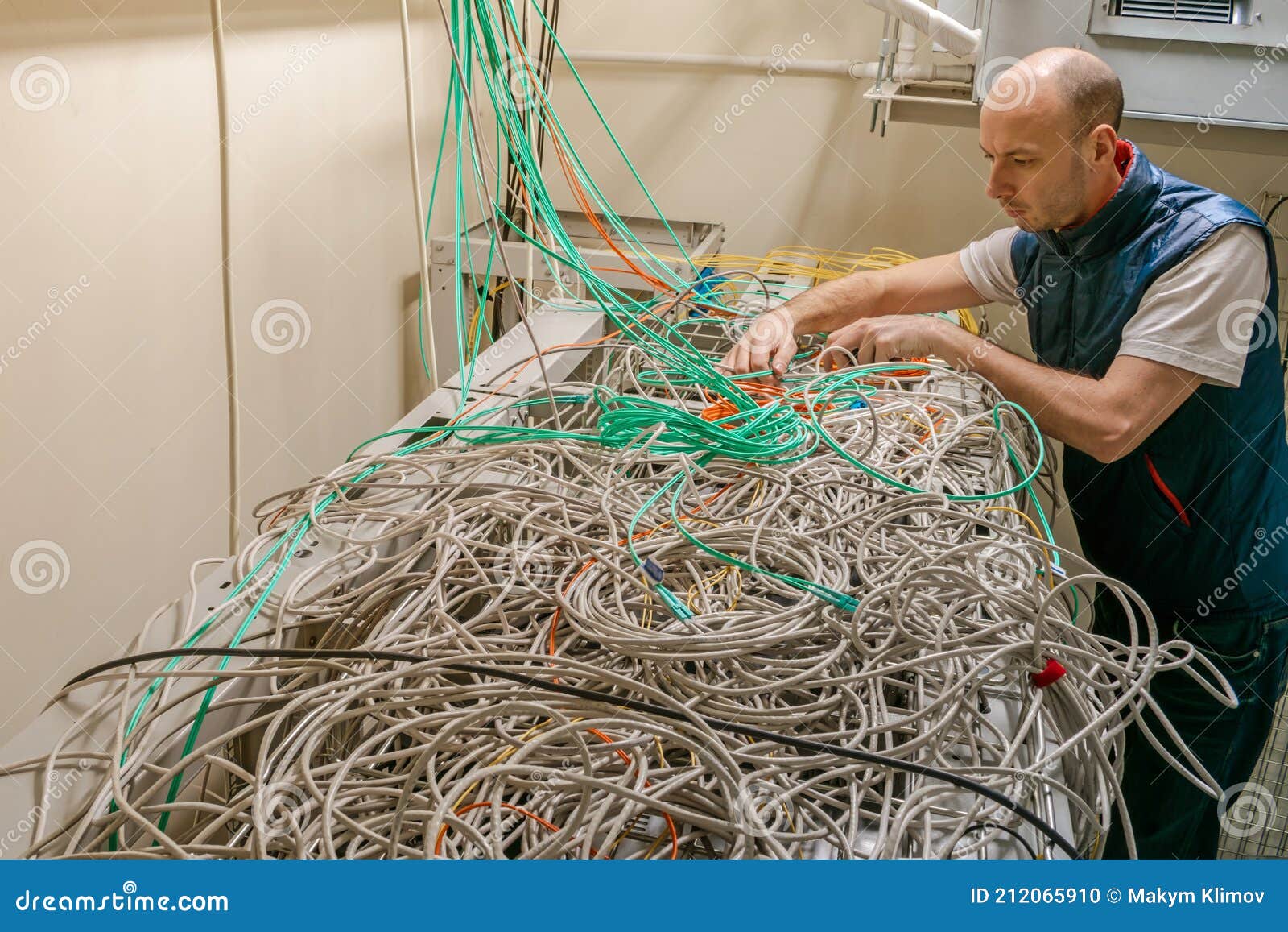 Communication Concept. a Technician Untangles a Lot of Cables on a ...