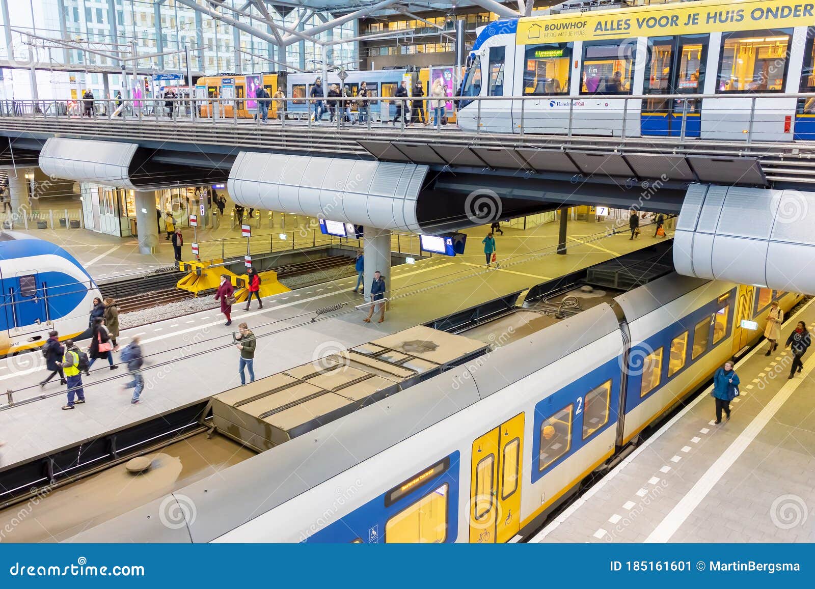 Commuters Waiting on Trains and Trams on a Two Level Station Platform ...