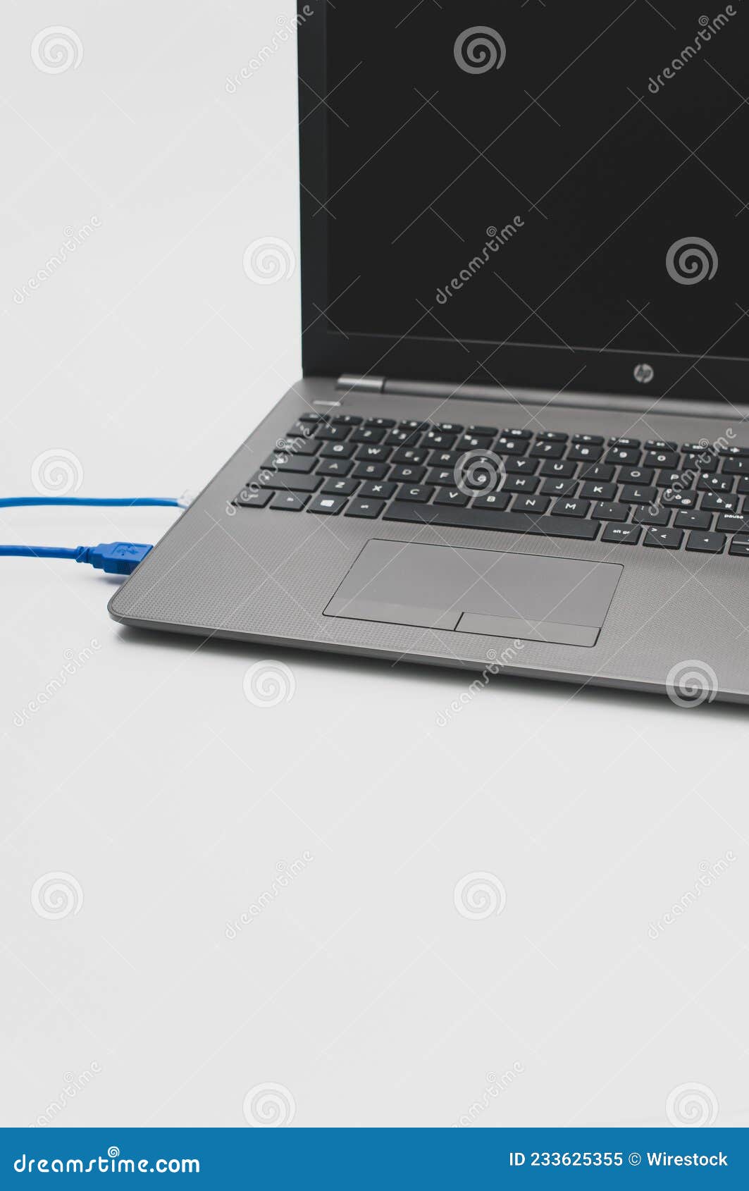 Dark Gray Laptop Computer and Blue Cables on a White Background ...